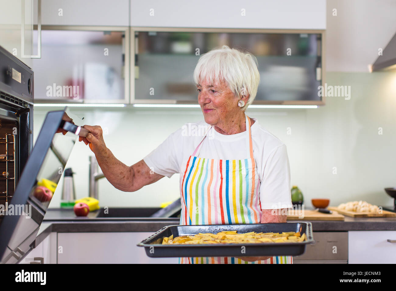 Senior woman cooking in the kitchen - eating and cooking healthy for ...