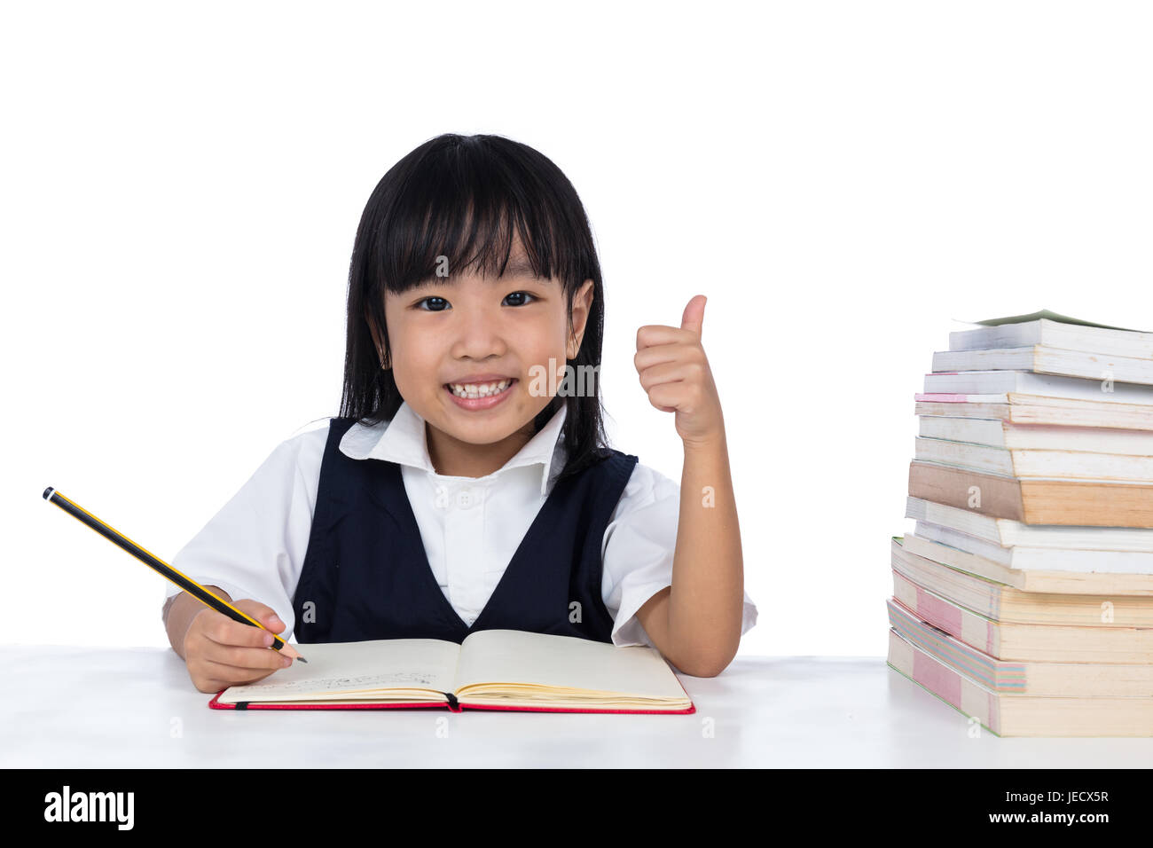 Asian Chinese little girl wearing school uniform studying with thumbs ...