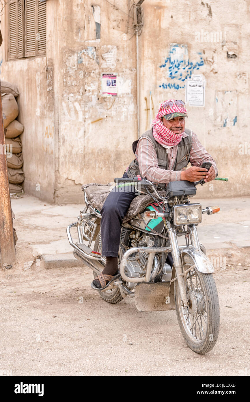 Syrian man wearing a kaffeyah while sitting on his motorcycle on a ...