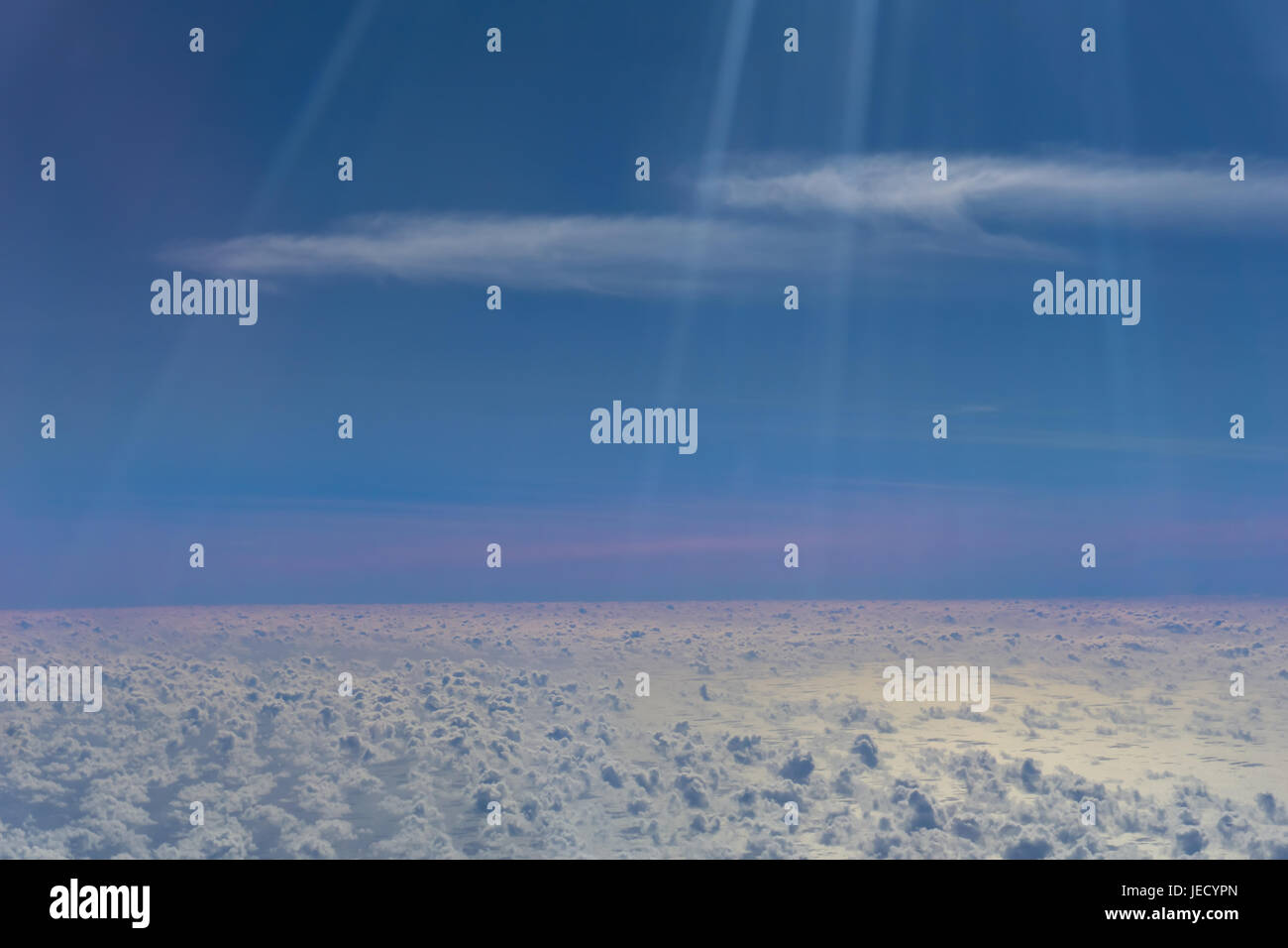 From above rays of sun create lens flare streaks through blue sky to ...