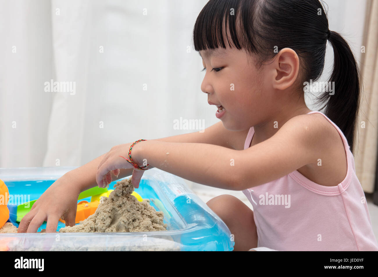 Asian Chinese little girl playing sand in the living room at home Stock ...