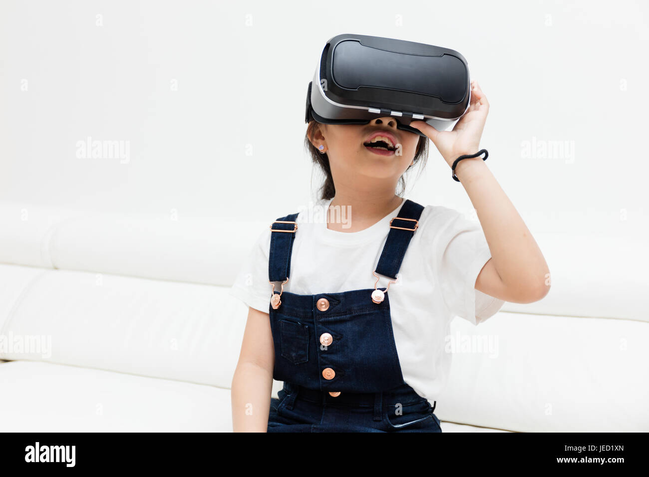 Asian Chinese little girl experiencing virtual reality with vr headset ...