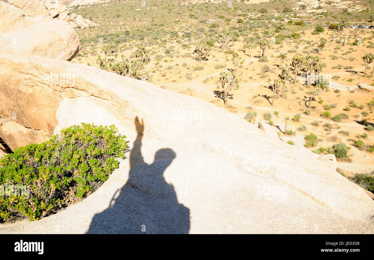 A man's shadow climbing rocks within the hall of horrors area of Joshua ...
