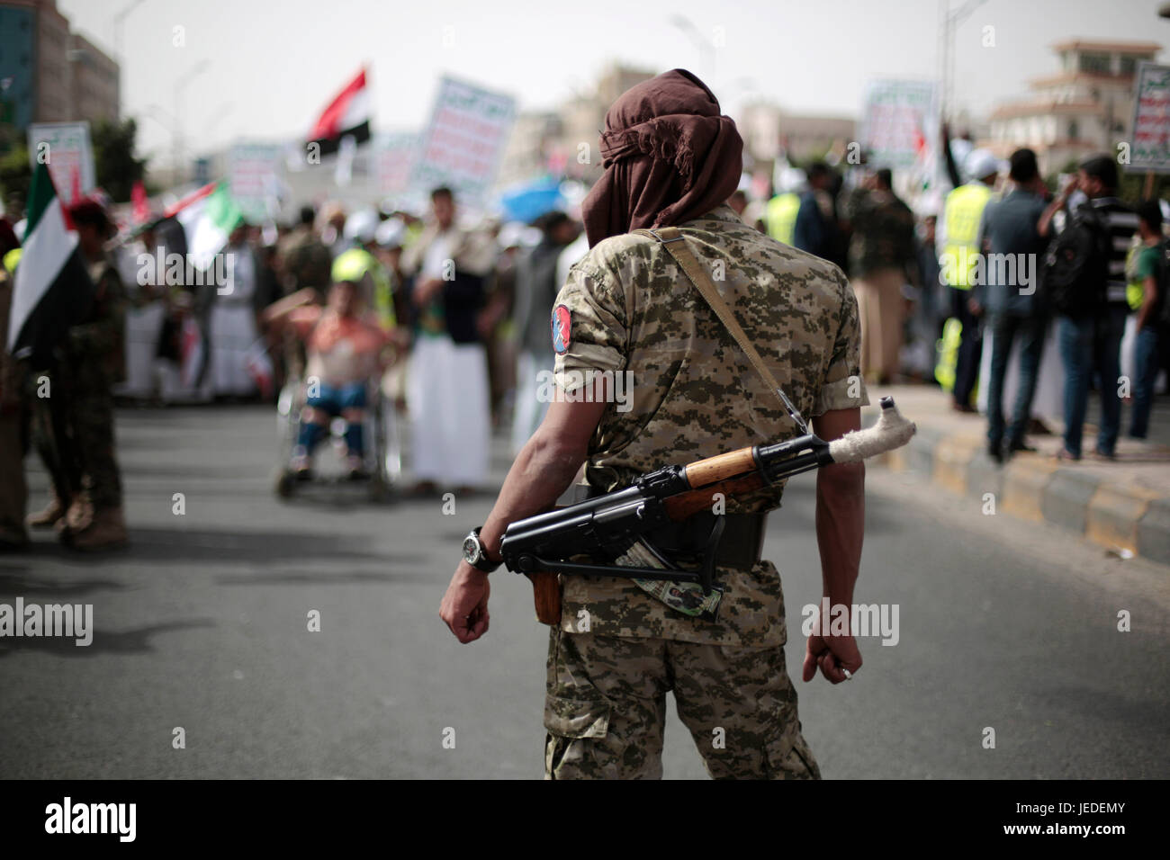 A Houthi rebel in camouflage uniform carries an assault rifle as he ...