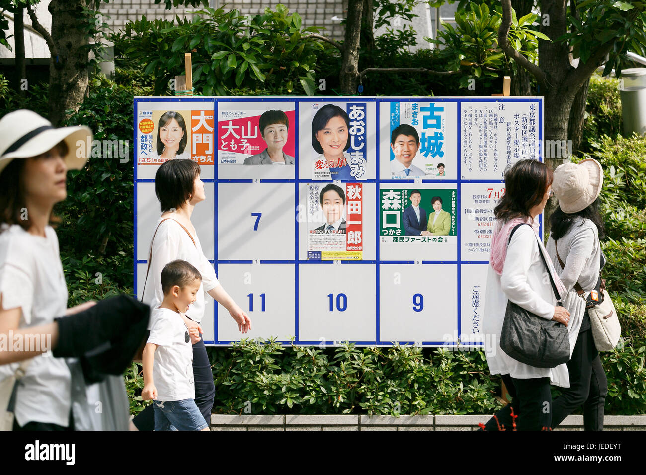 Tokyo, Japan. 24th June, 2017. Pedestrians walk past an election poster ...