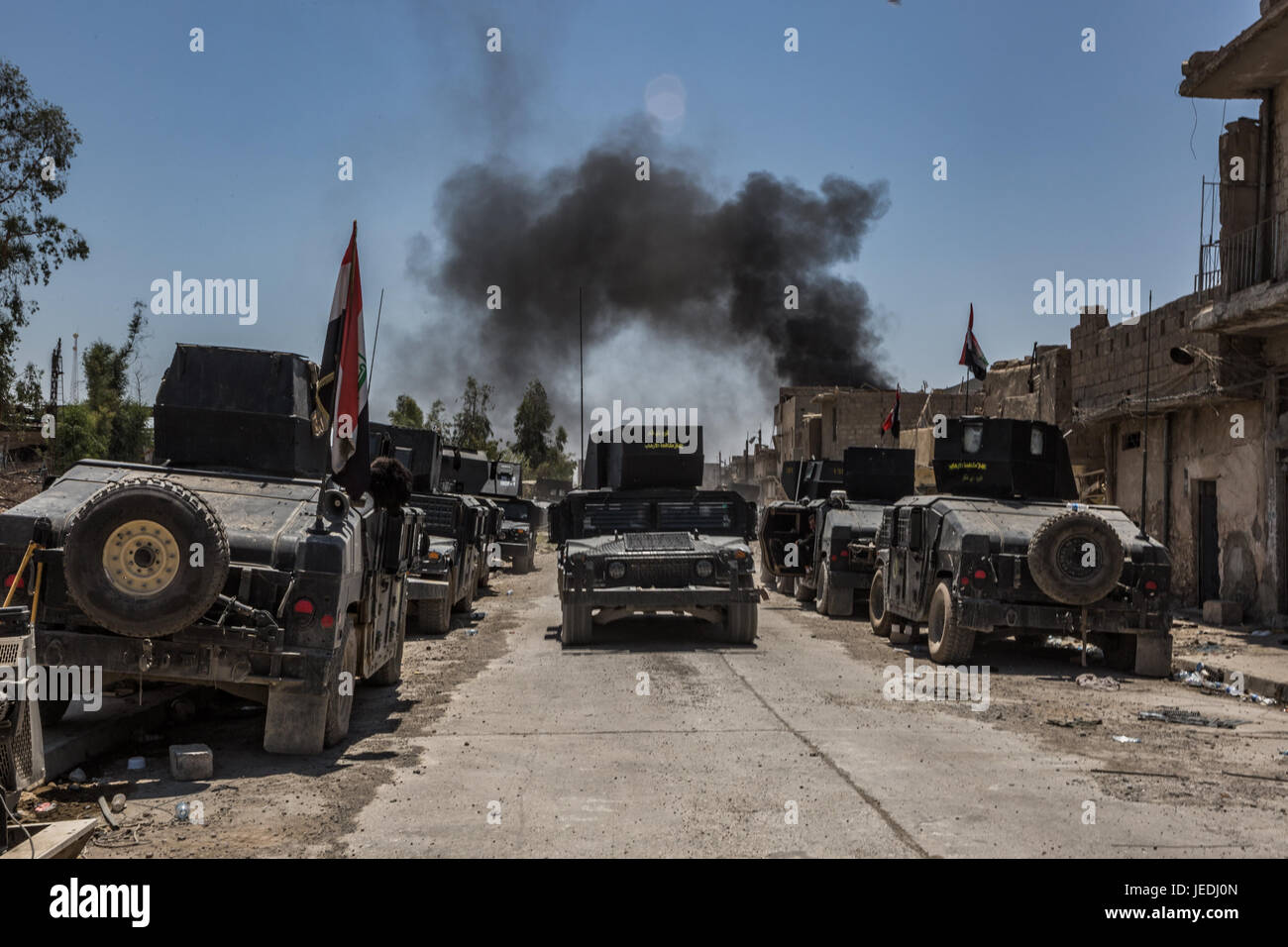 Iraqi military vehicles wait outside the the entrance to the Old City ...