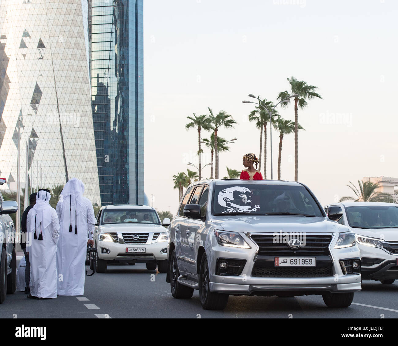 Doha, Qatar. 24th June, 2017. Qatari men watch the car parade along ...