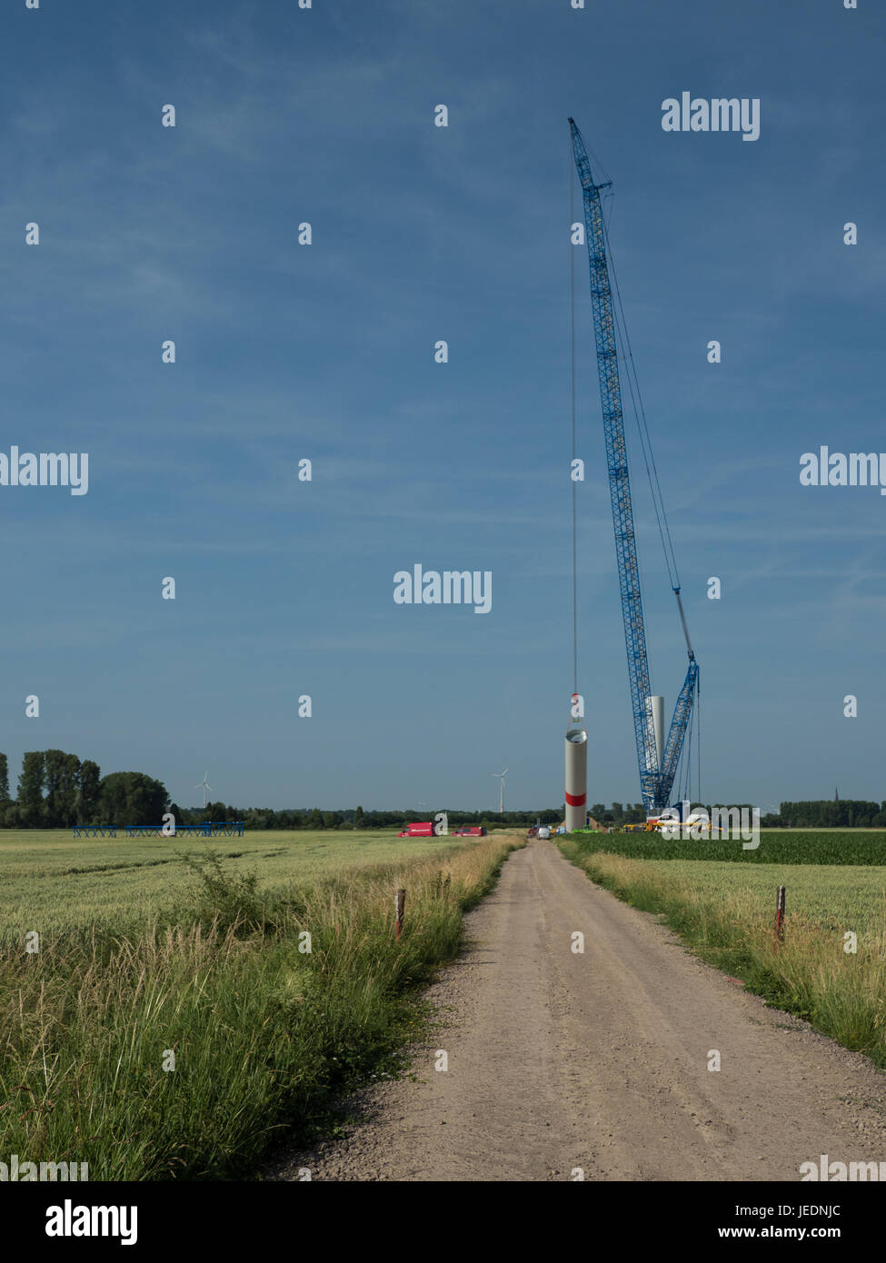 building a new wind power plant with a big blue crane, Kalkar, Germany ...