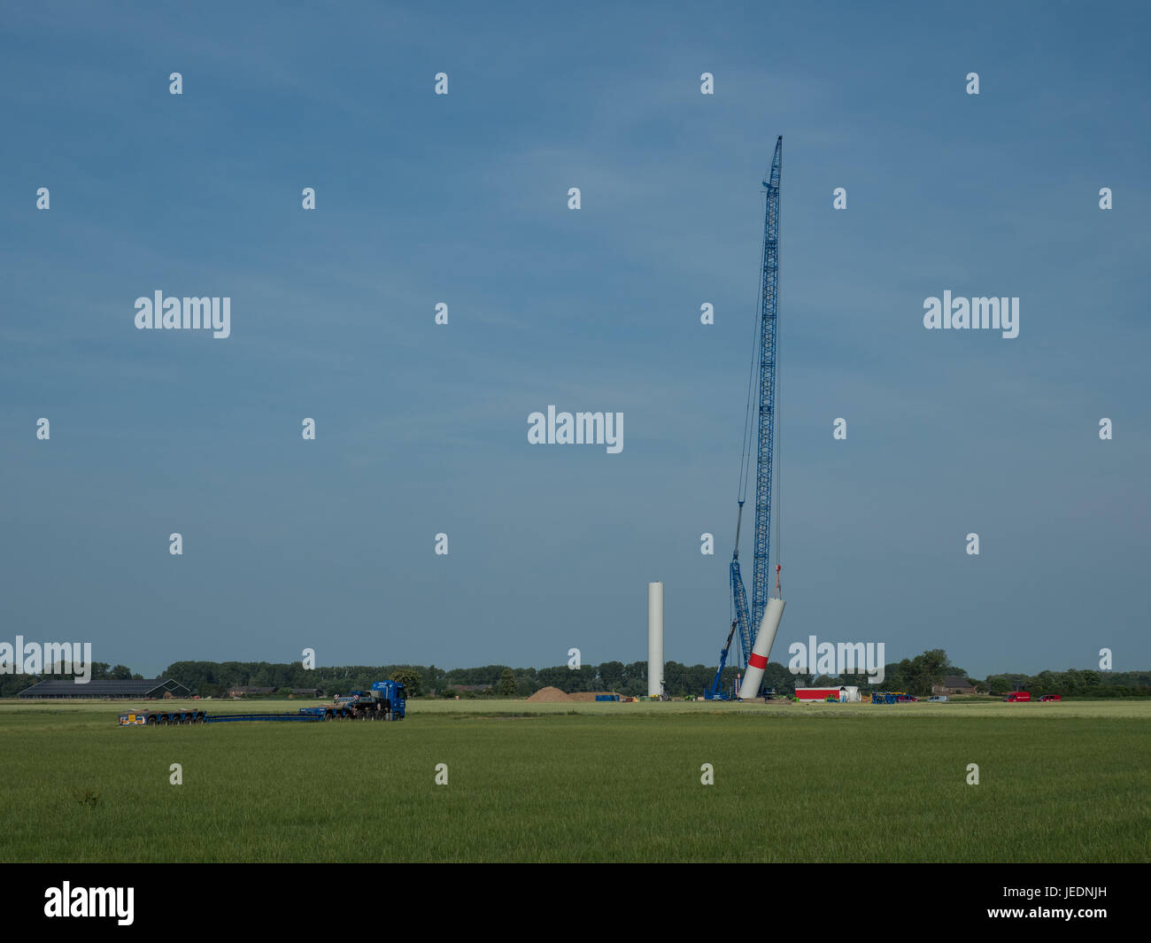 building a new wind power plant with a big blue crane, Kalkar, Germany ...