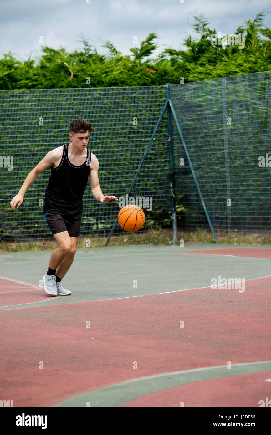 Boy dribbling basketball on outdoor court hi-res stock photography and ...