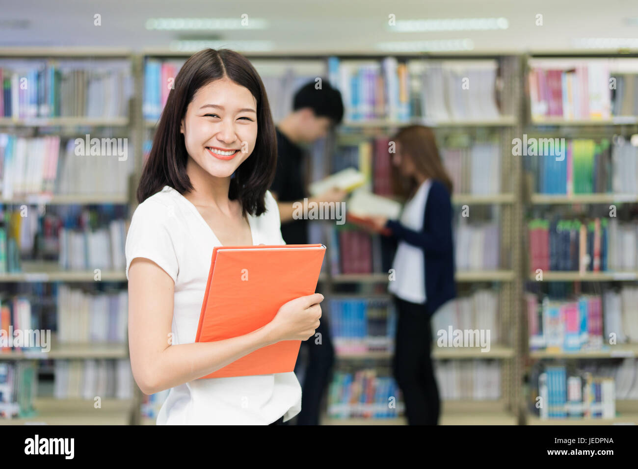 Group of Asian students studying together in library at university ...