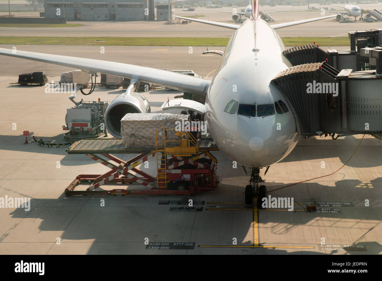 Loading cargo on plane in airport before flight Stock Photo - Alamy