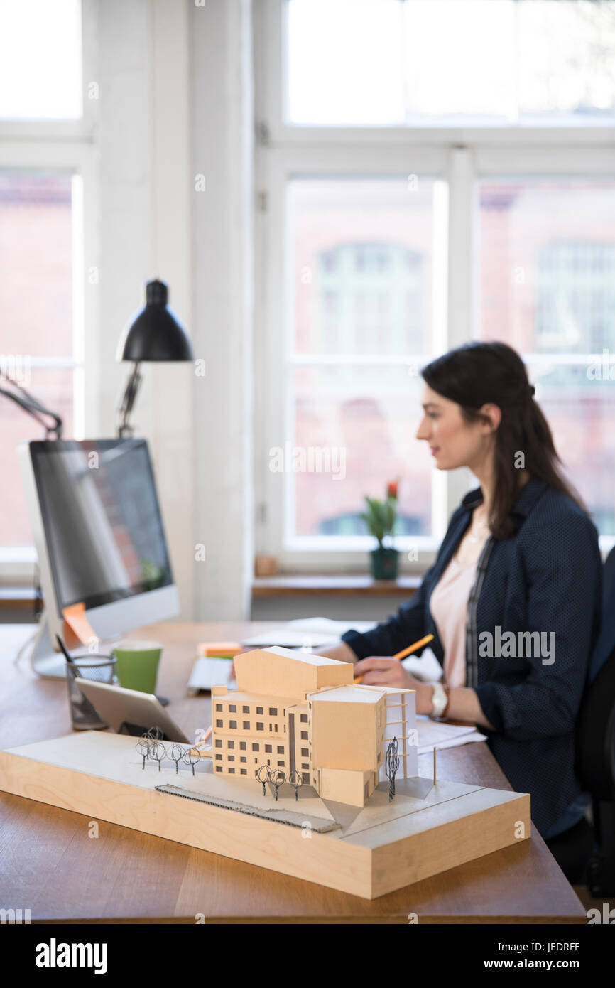 Architectural model and woman working at desk in office Stock Photo - Alamy