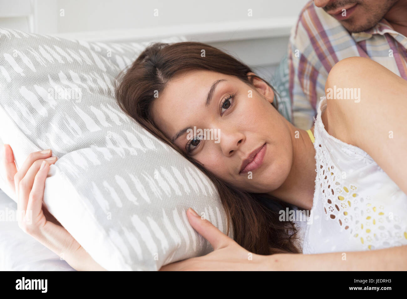 Young woman lying in bed with man Stock Photo - Alamy