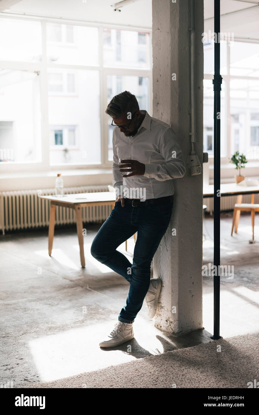 Worried businessman leaning against pillar hi-res stock photography and ...