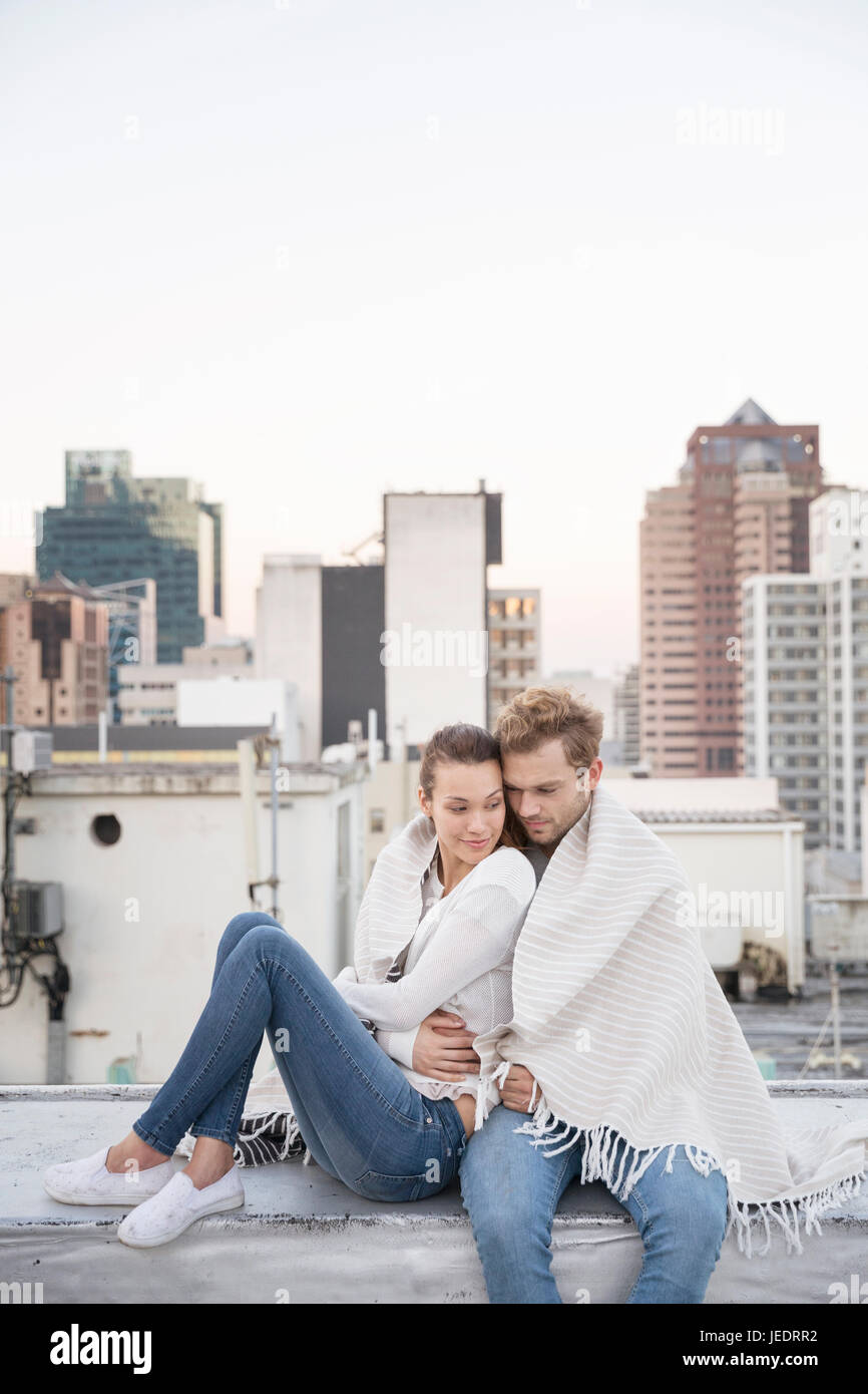 Romantic couple sitting on rooftop terrace, enjoying the view Stock ...