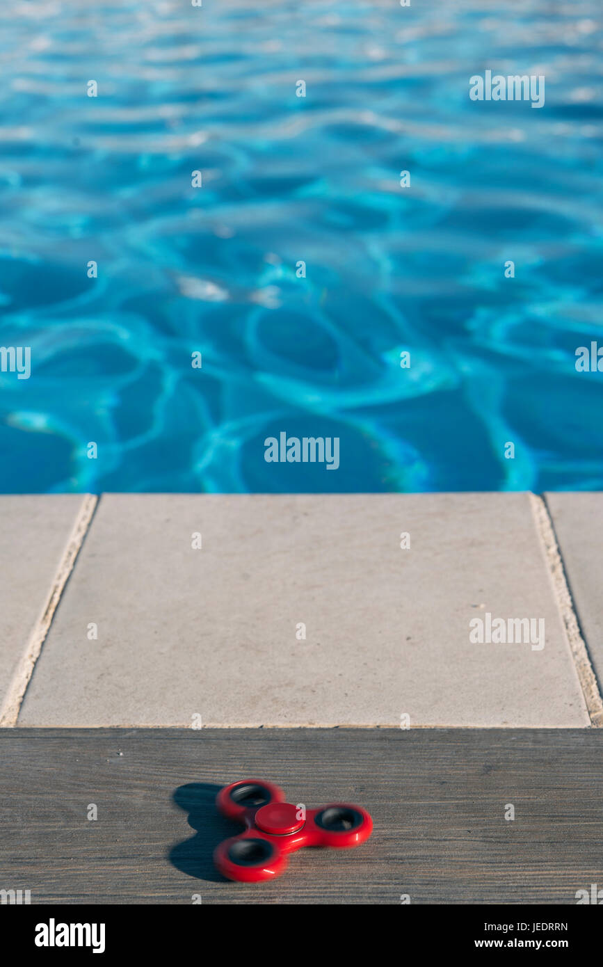 Fidget spinner lying at the edge of a swimming pool Stock Photo - Alamy
