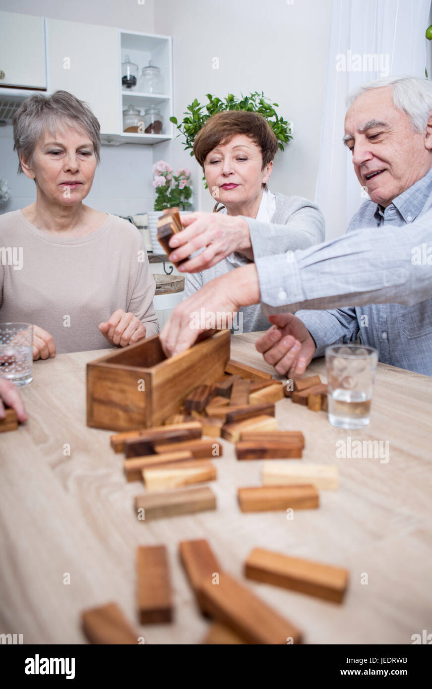 Group of seniors having a games evening at home Stock Photo - Alamy
