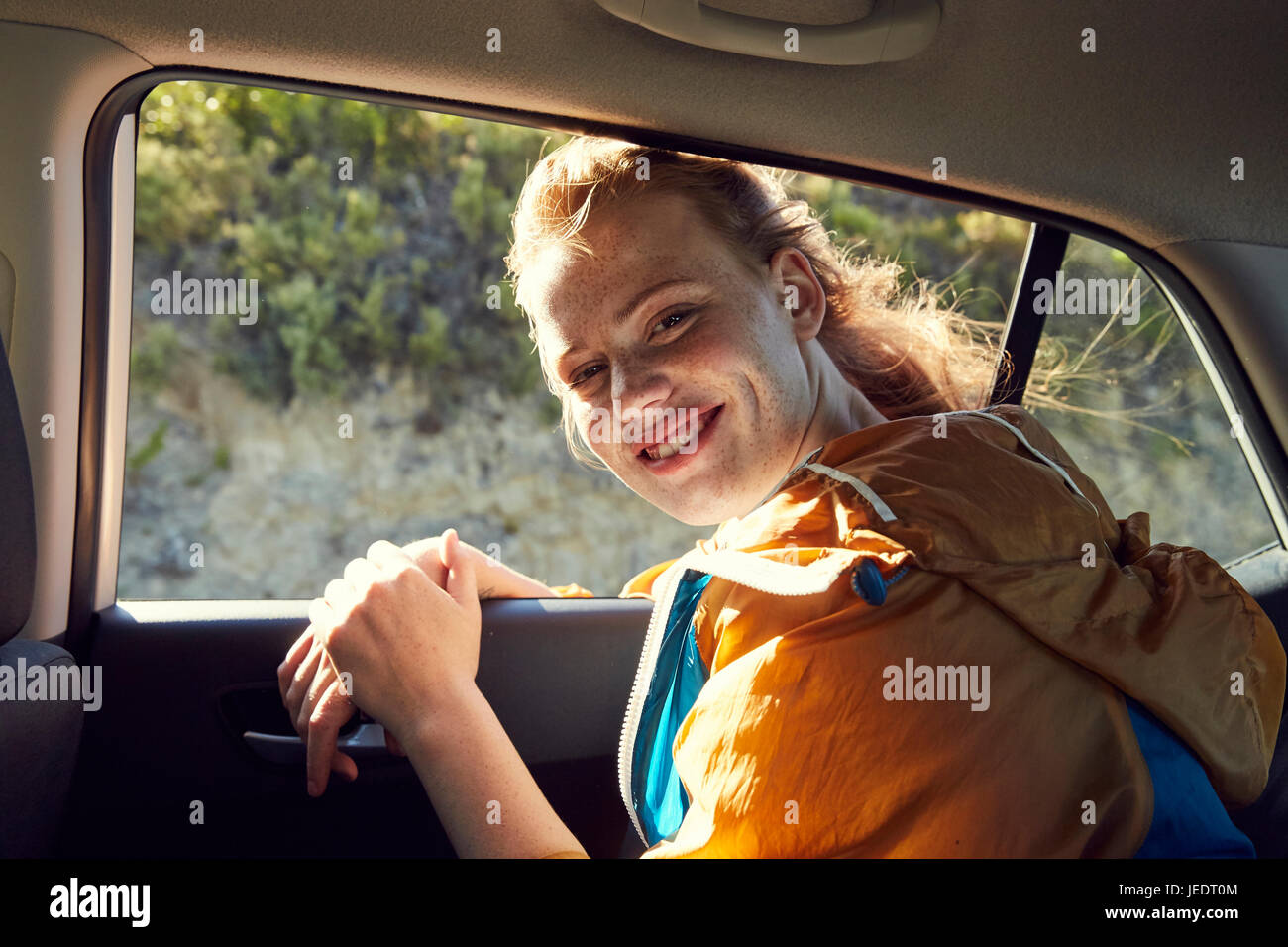 Smiling young woman on the back seat of a car Stock Photo - Alamy