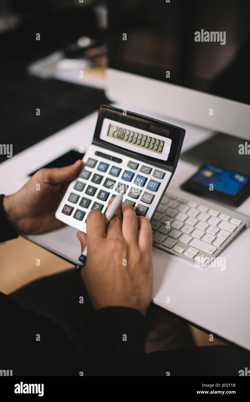 Man using calculator and credit card at desk hi-res stock photography ...