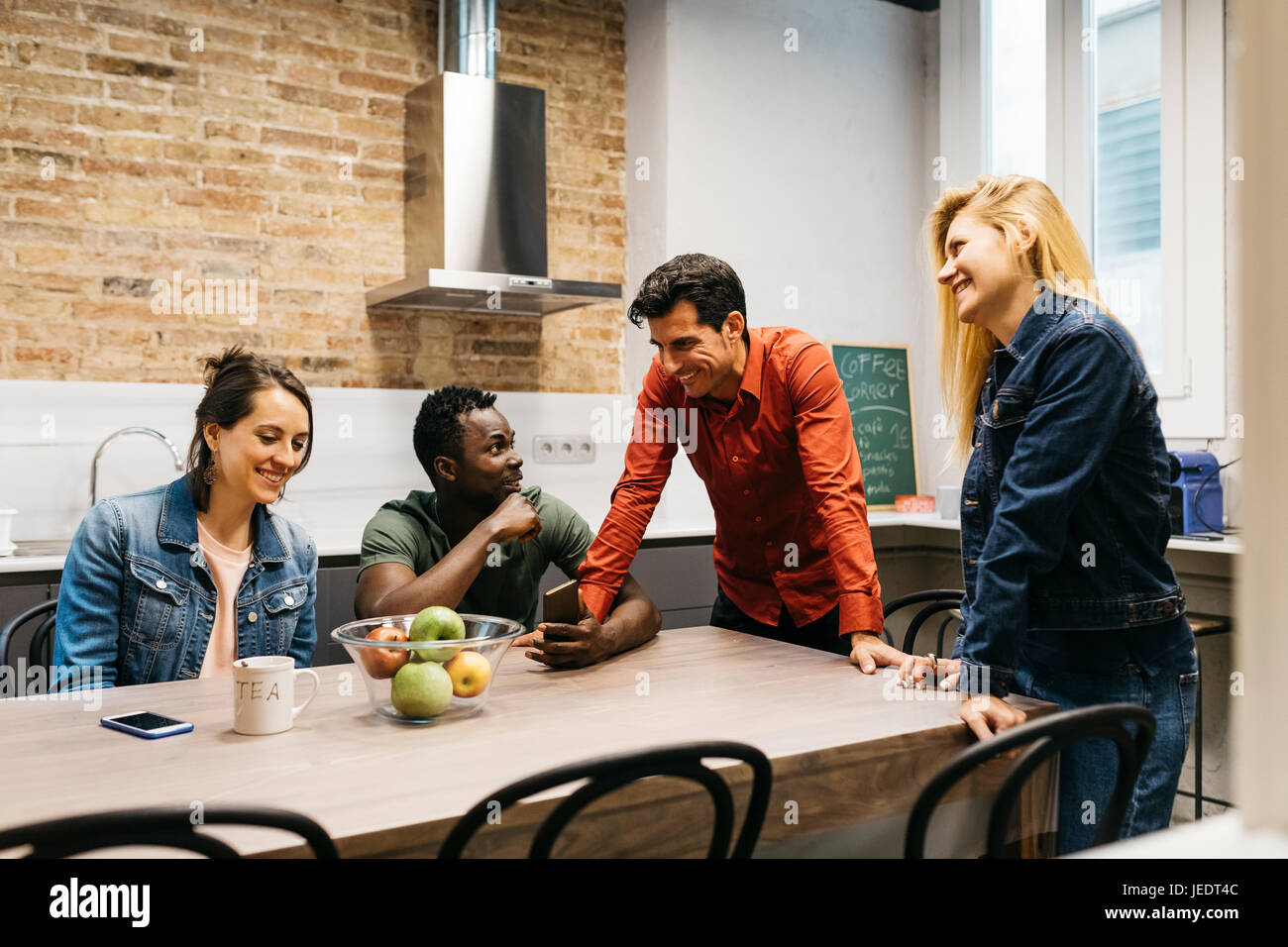Colleagues having a break in office kitchen Stock Photo - Alamy