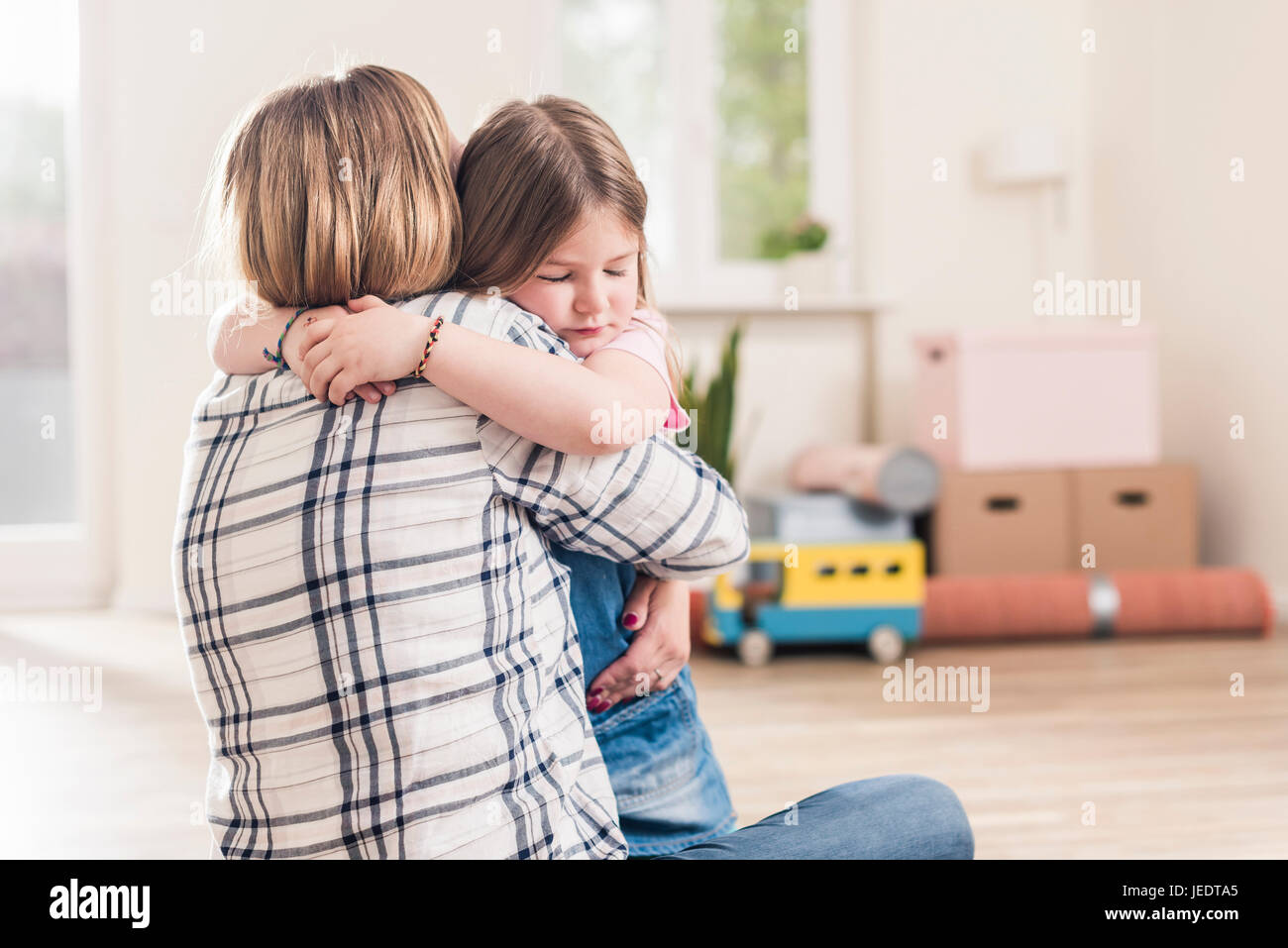 Mother and daughter hugging in empty apartment Stock Photo - Alamy