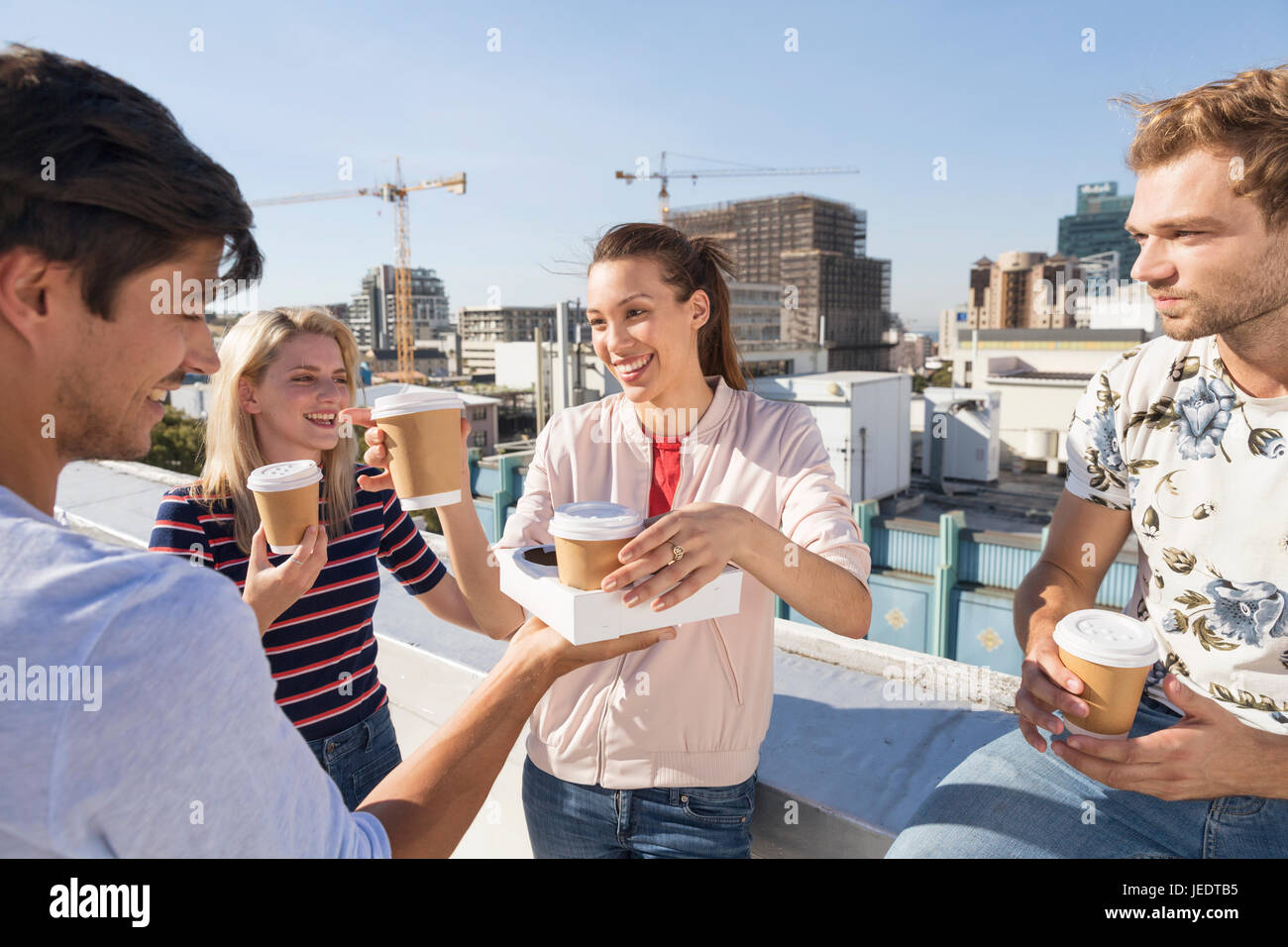 Friends drinking coffee on a rooftop terrace Stock Photo - Alamy