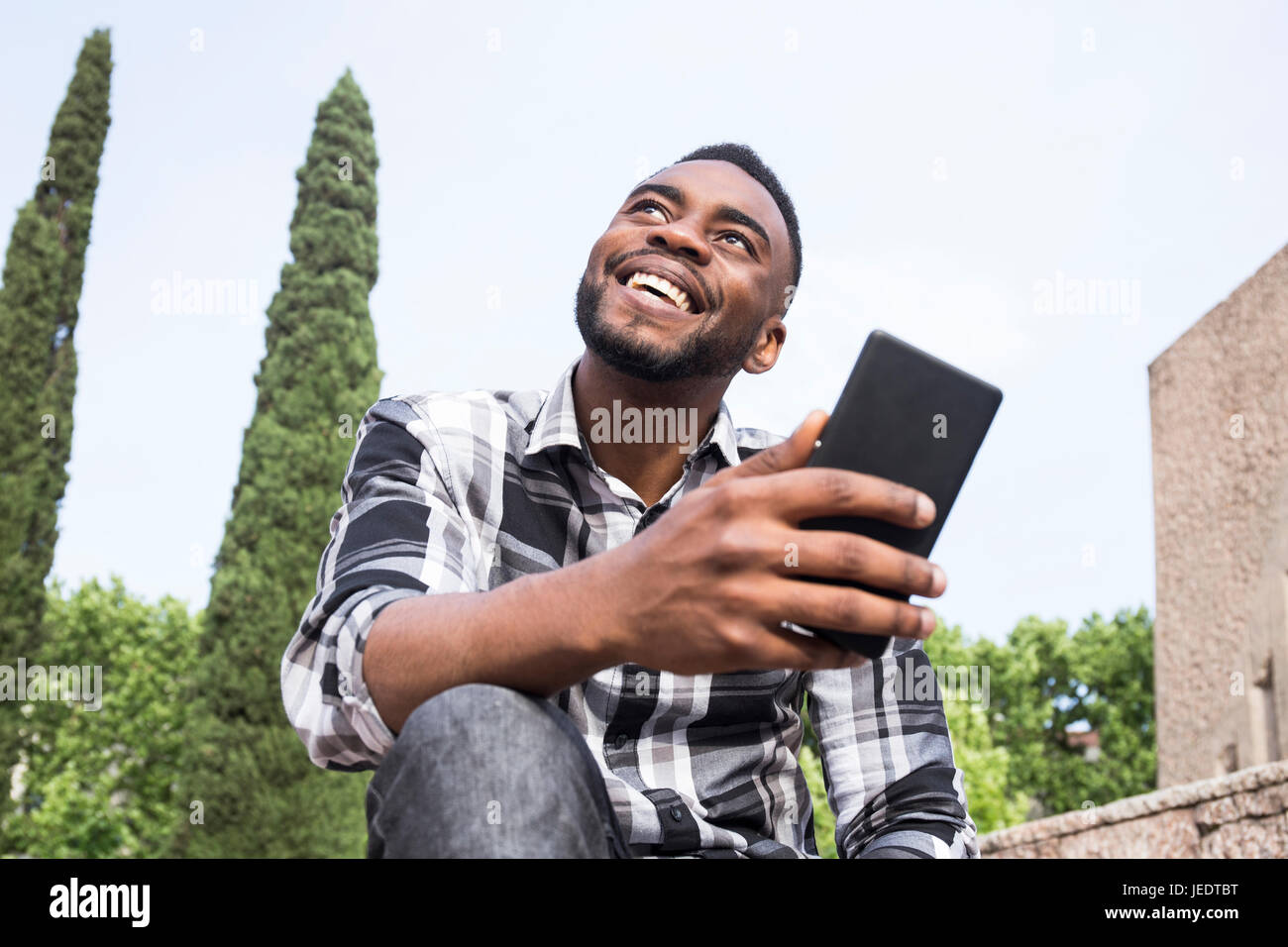 Portrait of happy young man with cell phone Stock Photo - Alamy