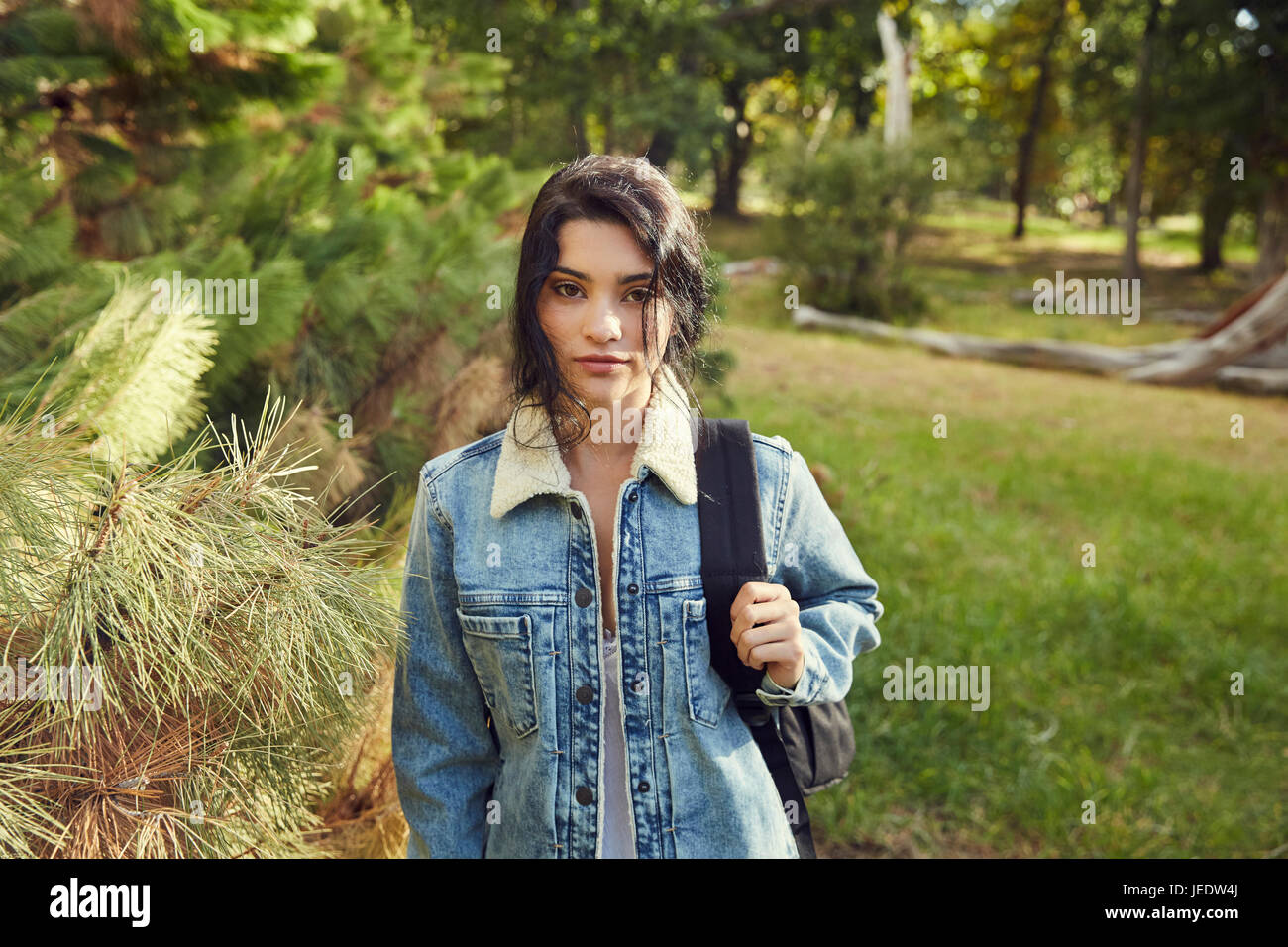Portrait of young woman with backpack in nature Stock Photo - Alamy