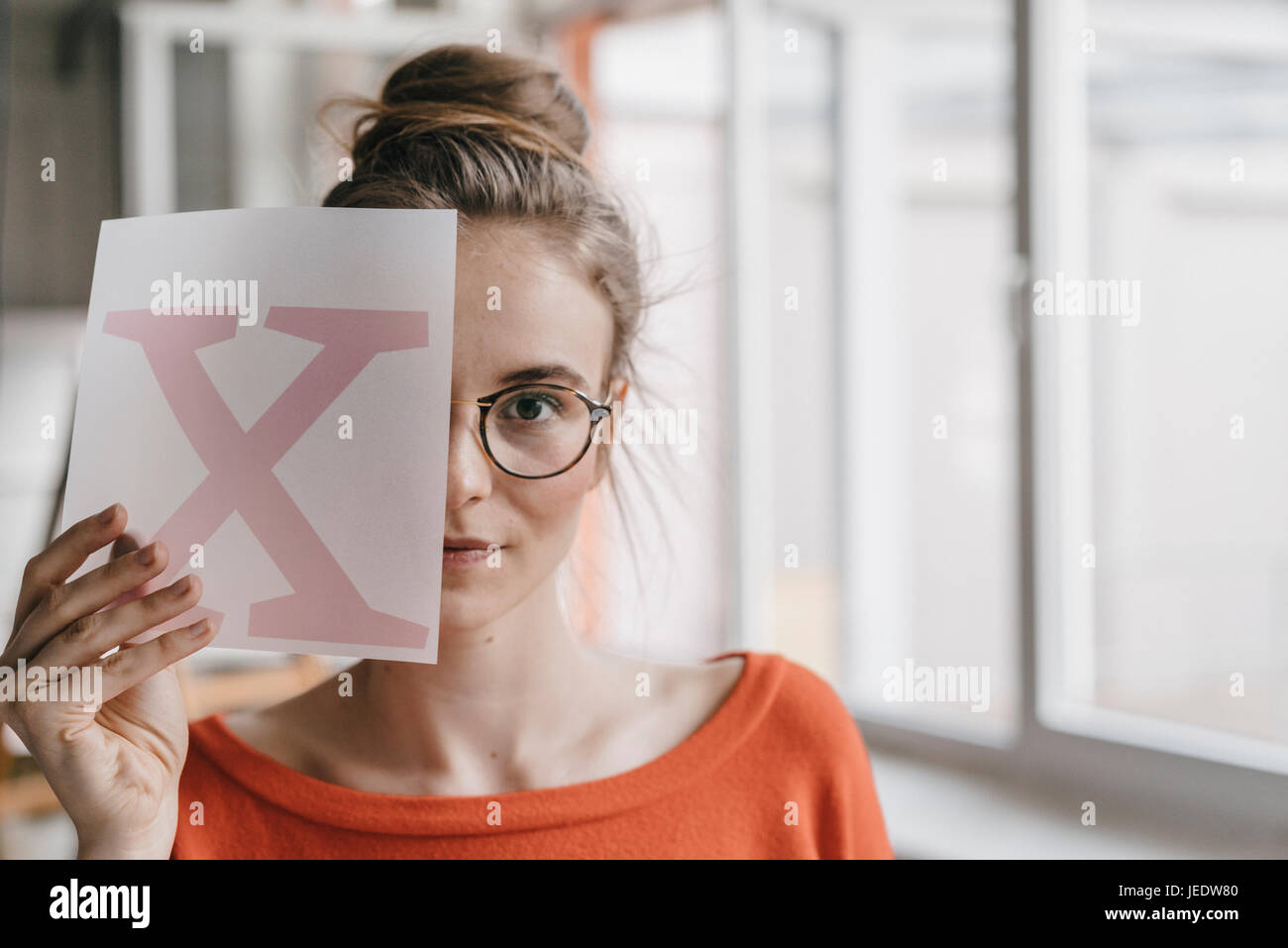 Portrait of young woman holding letter x template Stock Photo - Alamy