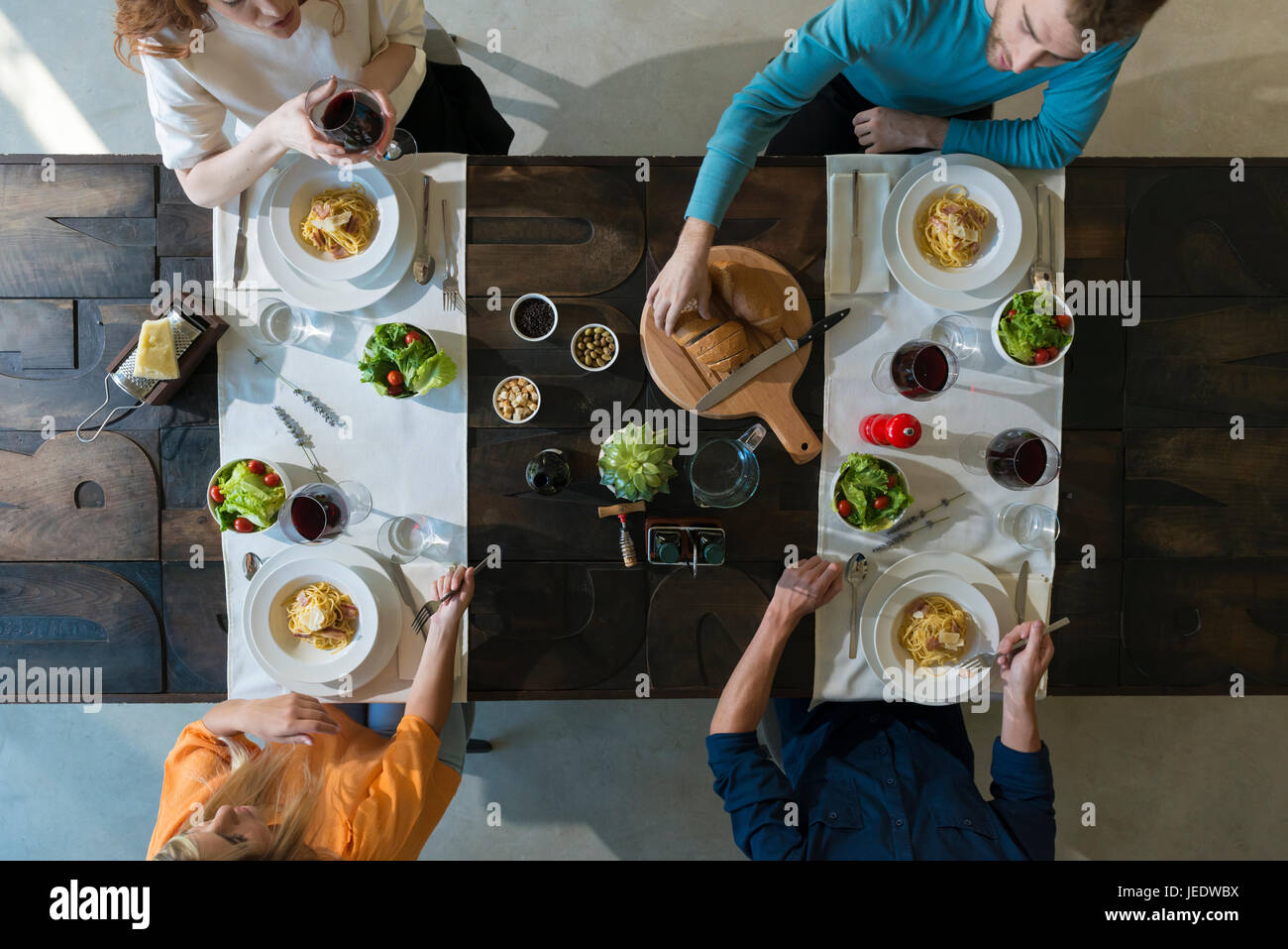 Friends eating together spaghetti carbonara Stock Photo - Alamy