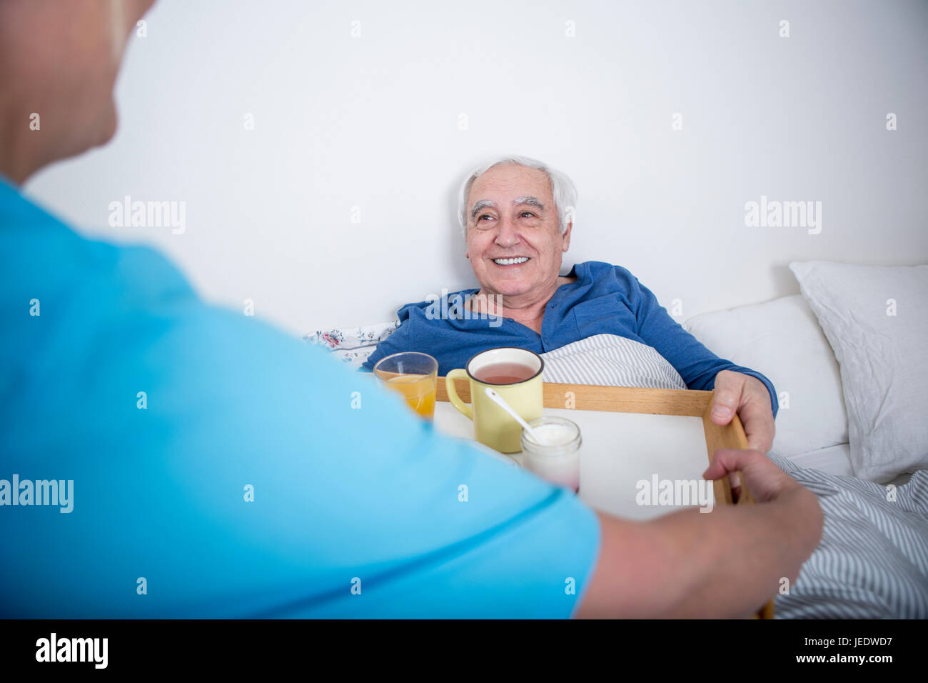 Gereatric nurse bringing tea at patient's bed Stock Photo - Alamy