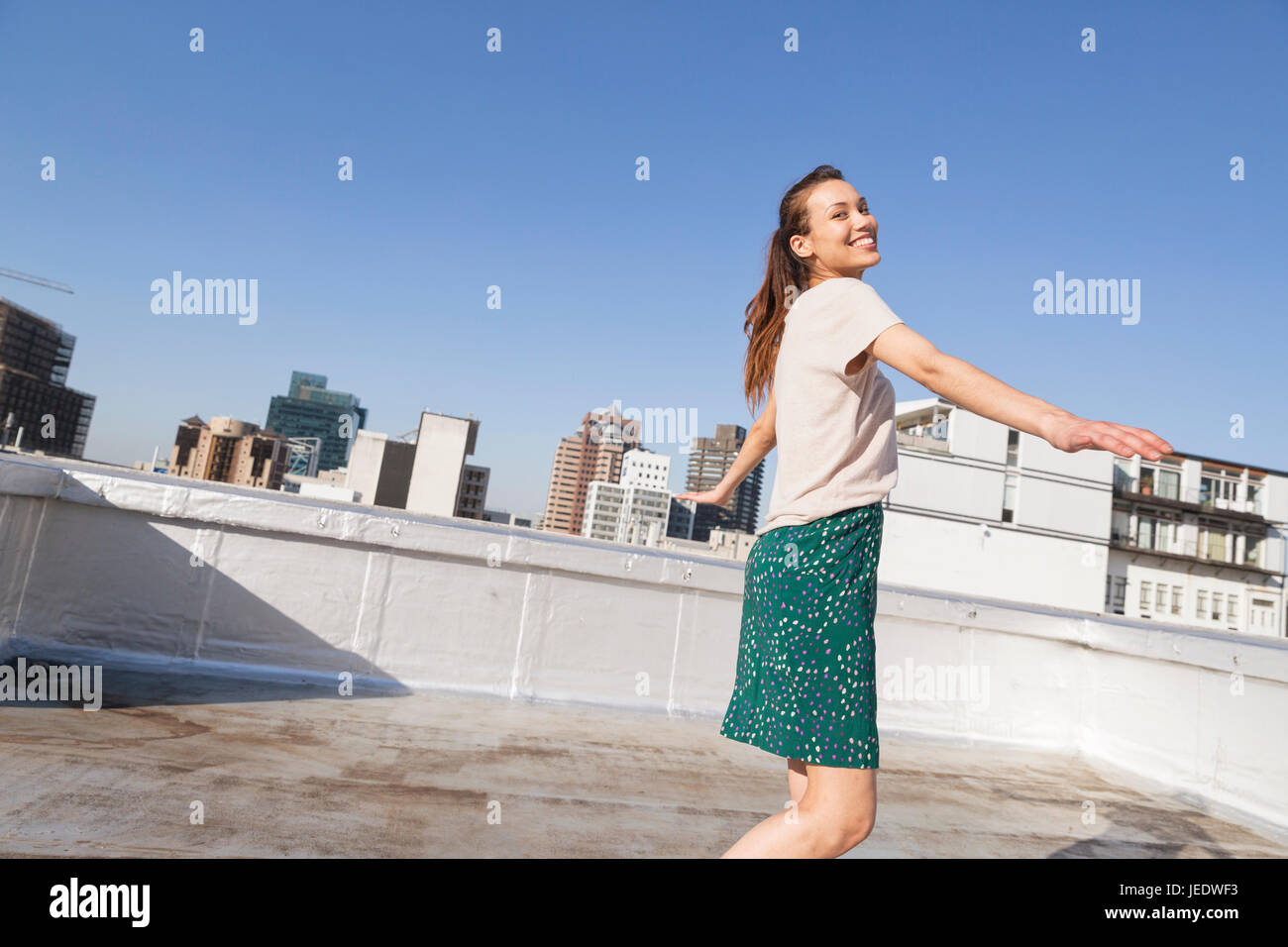 Young woman dancing on a rooftop terrace Stock Photo - Alamy
