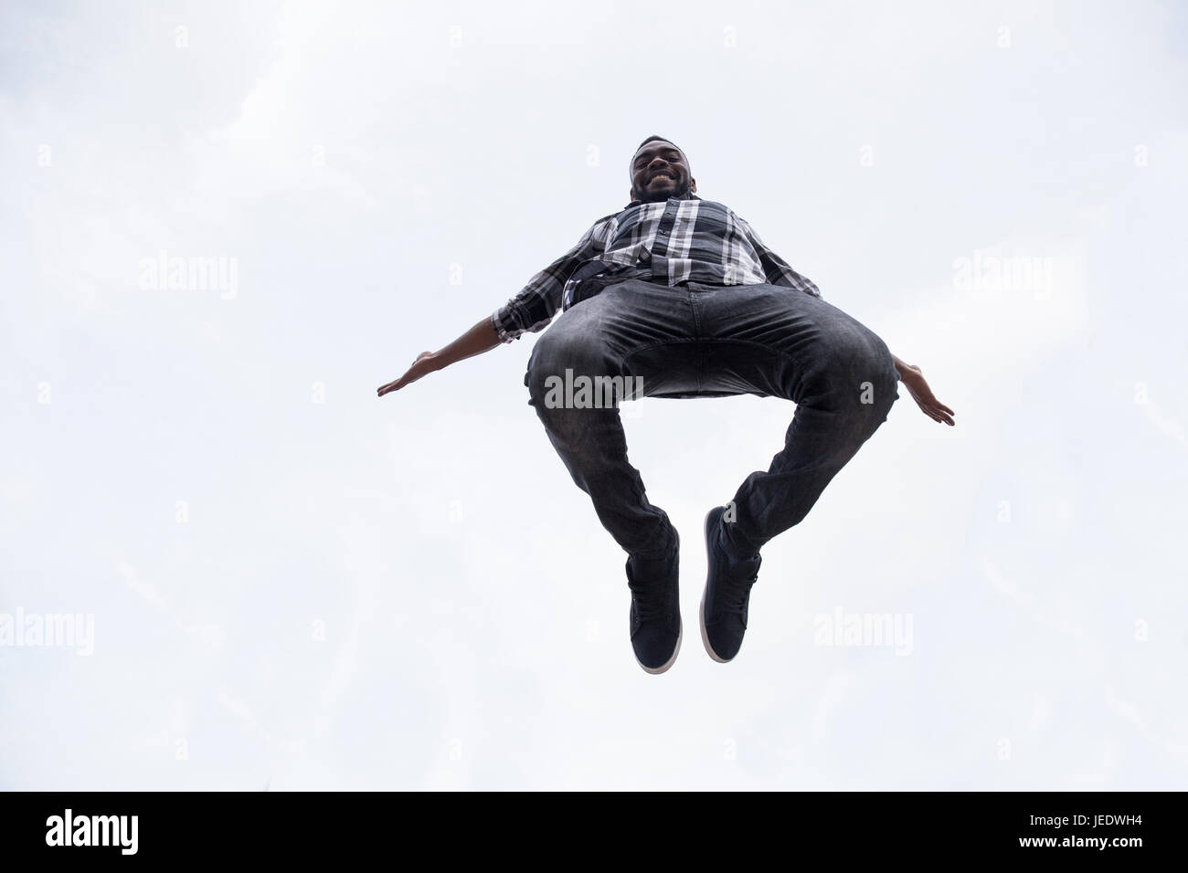 Happy young man jumping in the air Stock Photo - Alamy