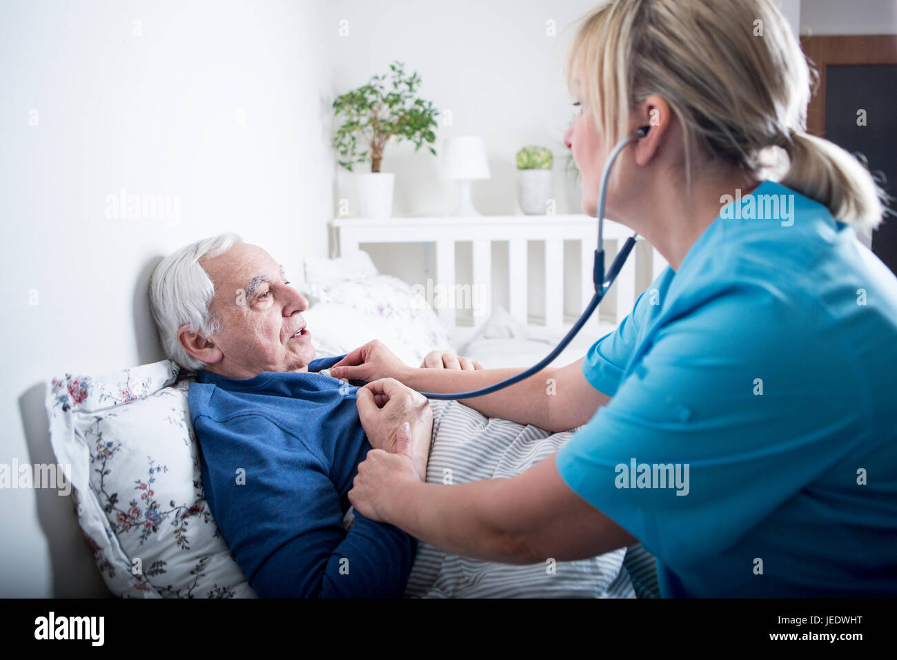 Gereatric nurse using stethoscope on patient Stock Photo - Alamy