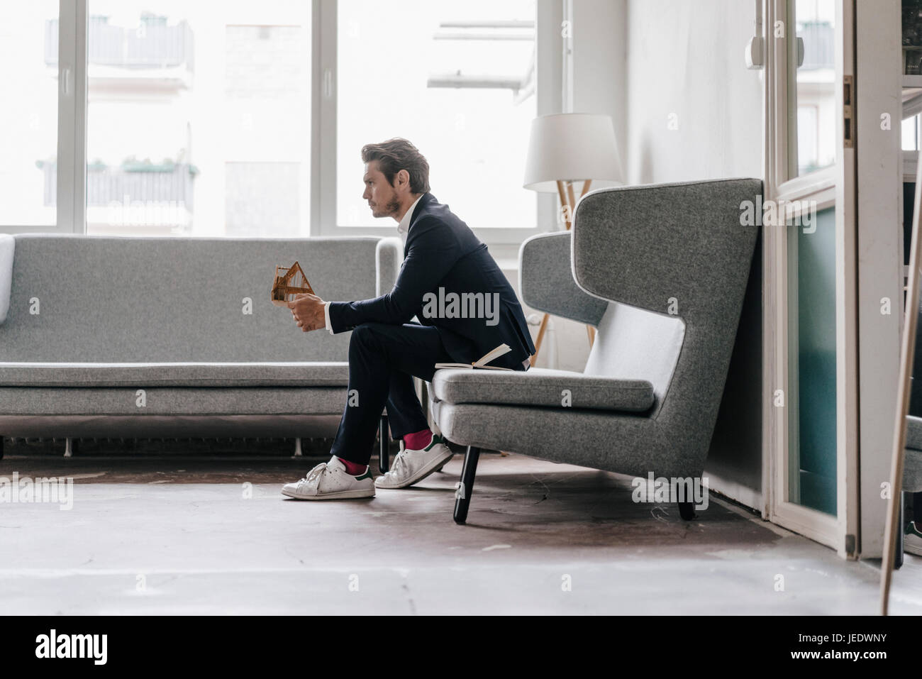Architect on couch holding architectural model Stock Photo - Alamy