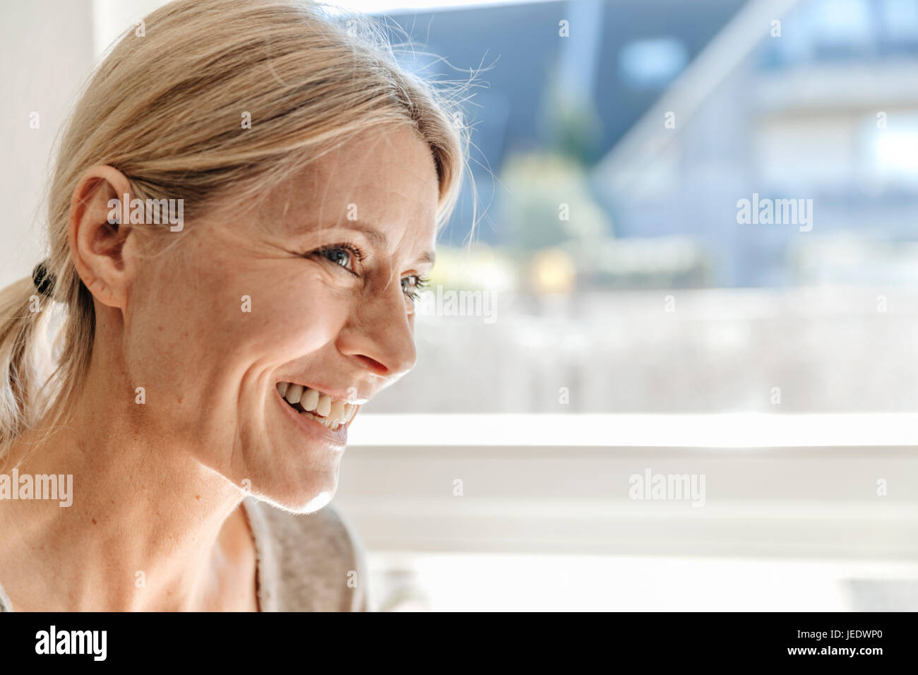 Portrait of smiling woman at home Stock Photo - Alamy