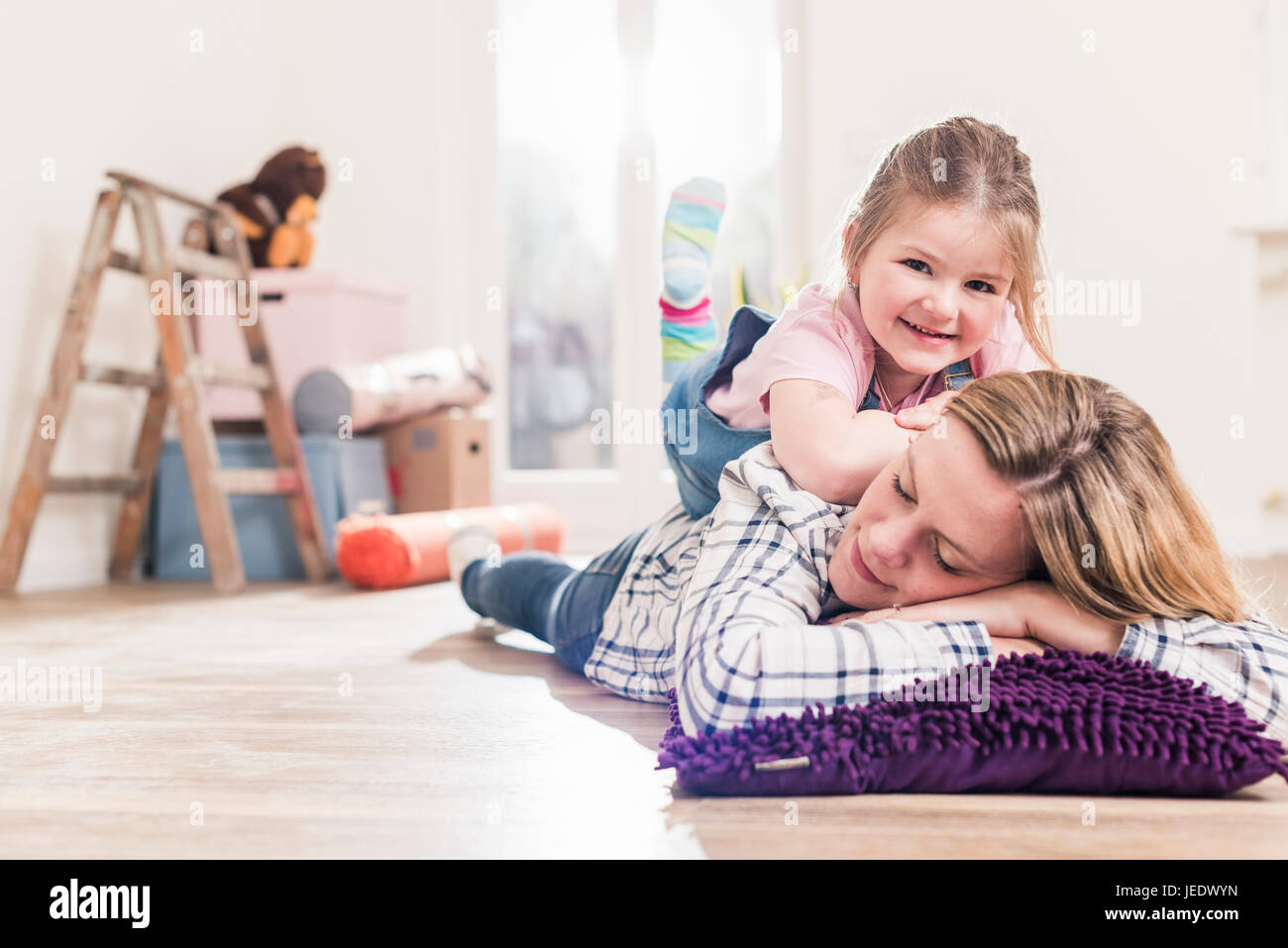 Mother and daughter having a break in new home Stock Photo - Alamy