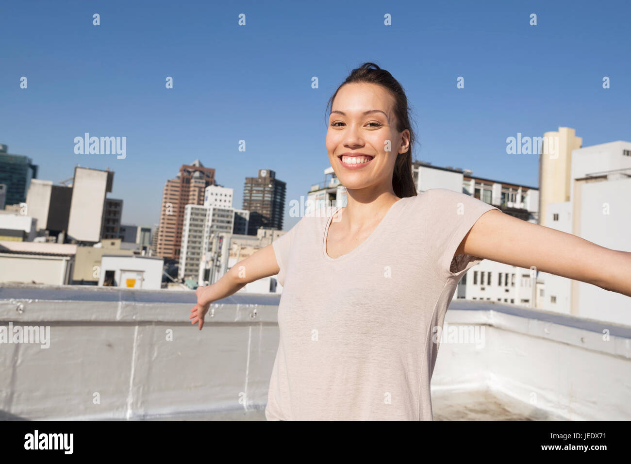 Young woman dancing on a rooftop terrace Stock Photo - Alamy