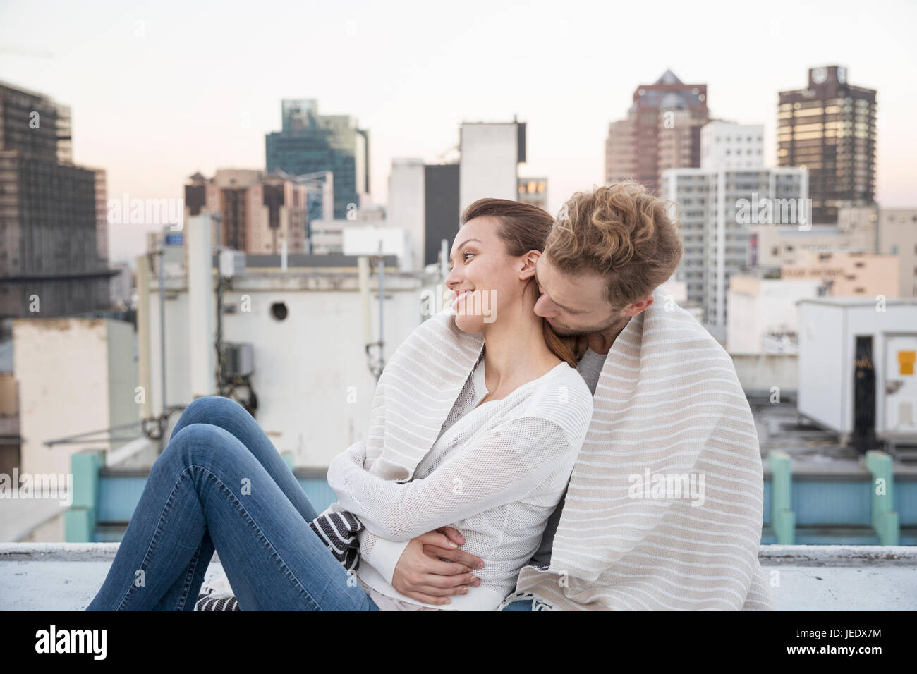 Romantic couple sitting on rooftop terrace, enjoying the view Stock ...