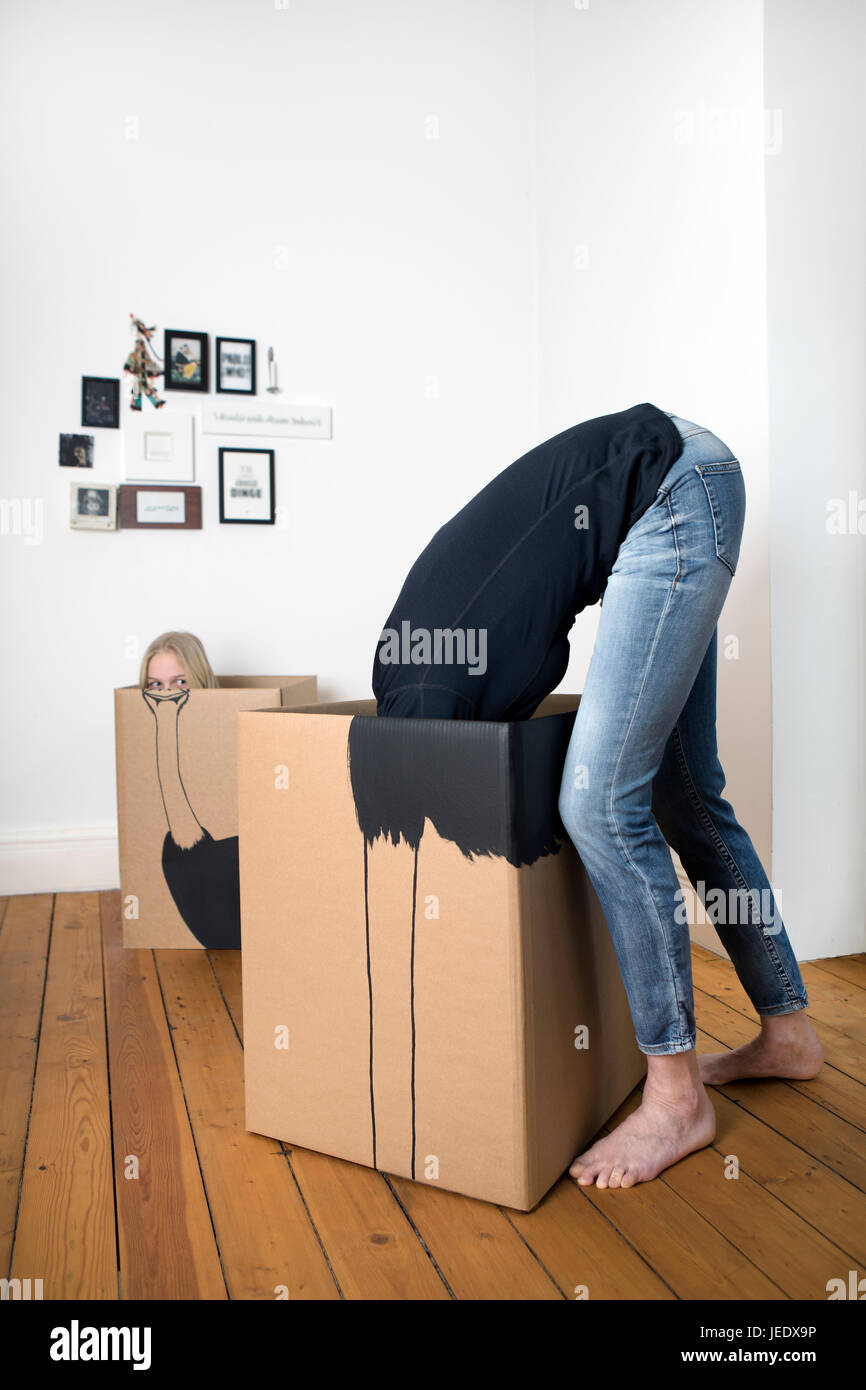 Girl and adult inside cardboard boxes painted with an ostriches Stock ...