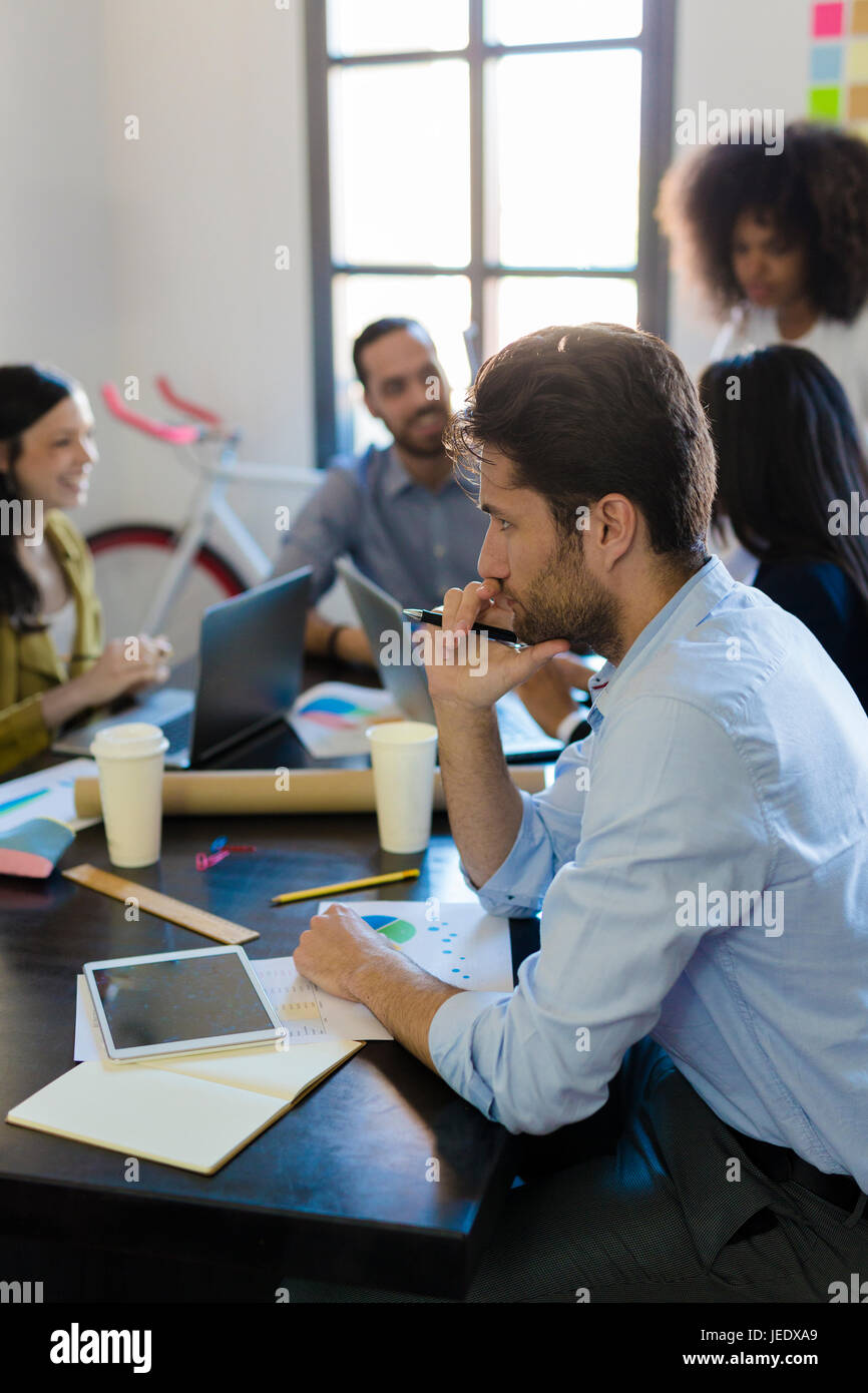 Businessman thinking during a meeting in office Stock Photo - Alamy