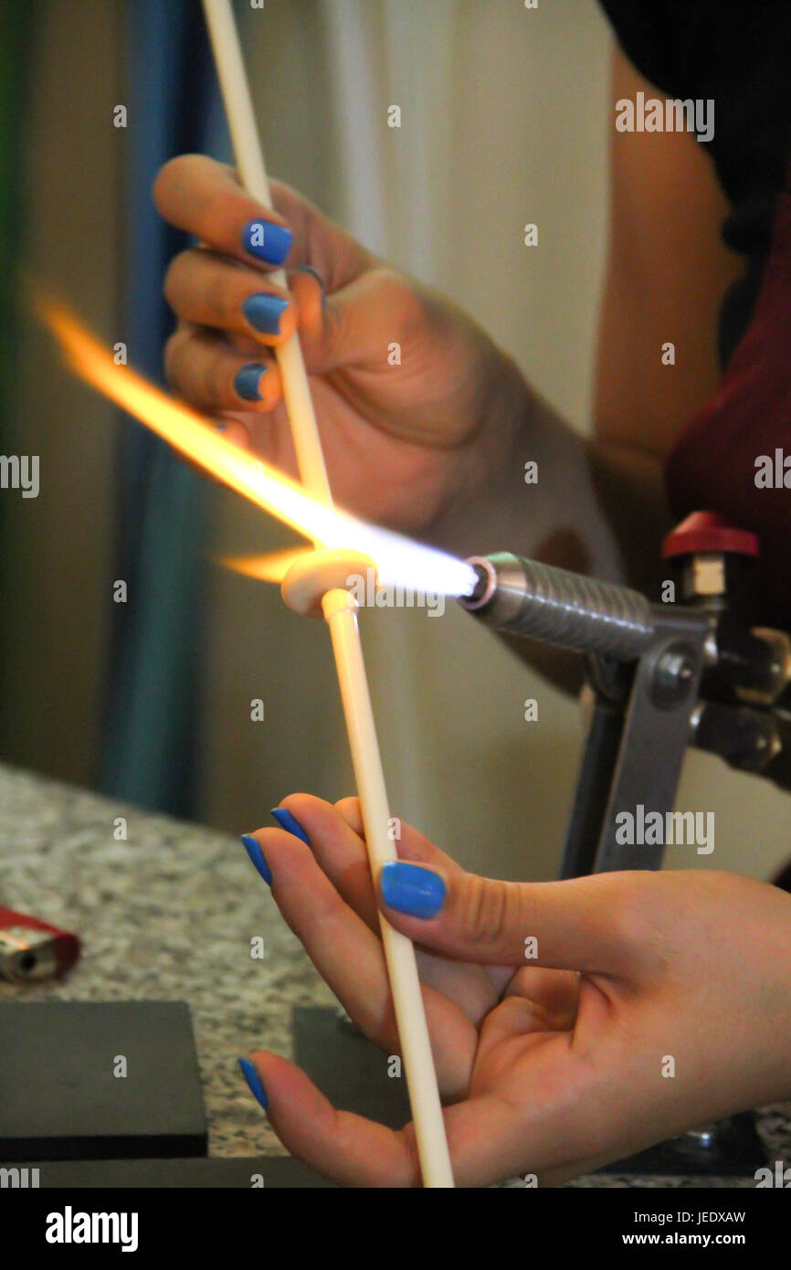 Woman firing glass bead Stock Photo - Alamy