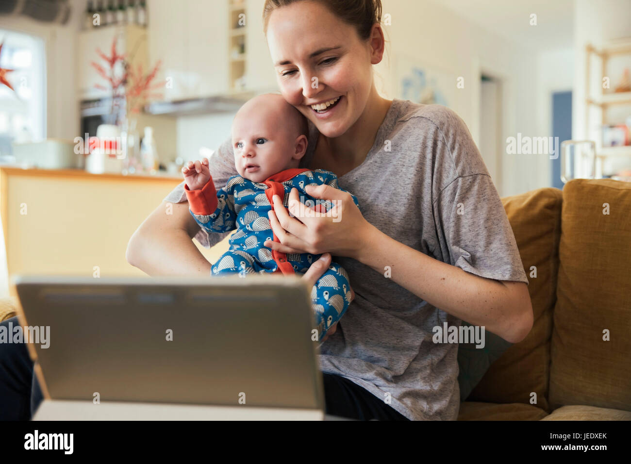 Mother and newborn baby taking a video call at home Stock Photo - Alamy