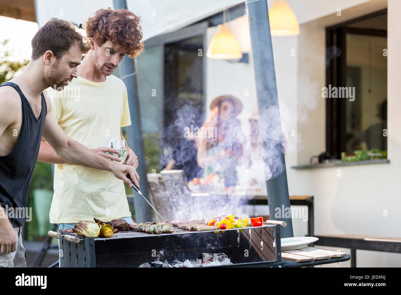 Two men at barbecue grill Stock Photo - Alamy