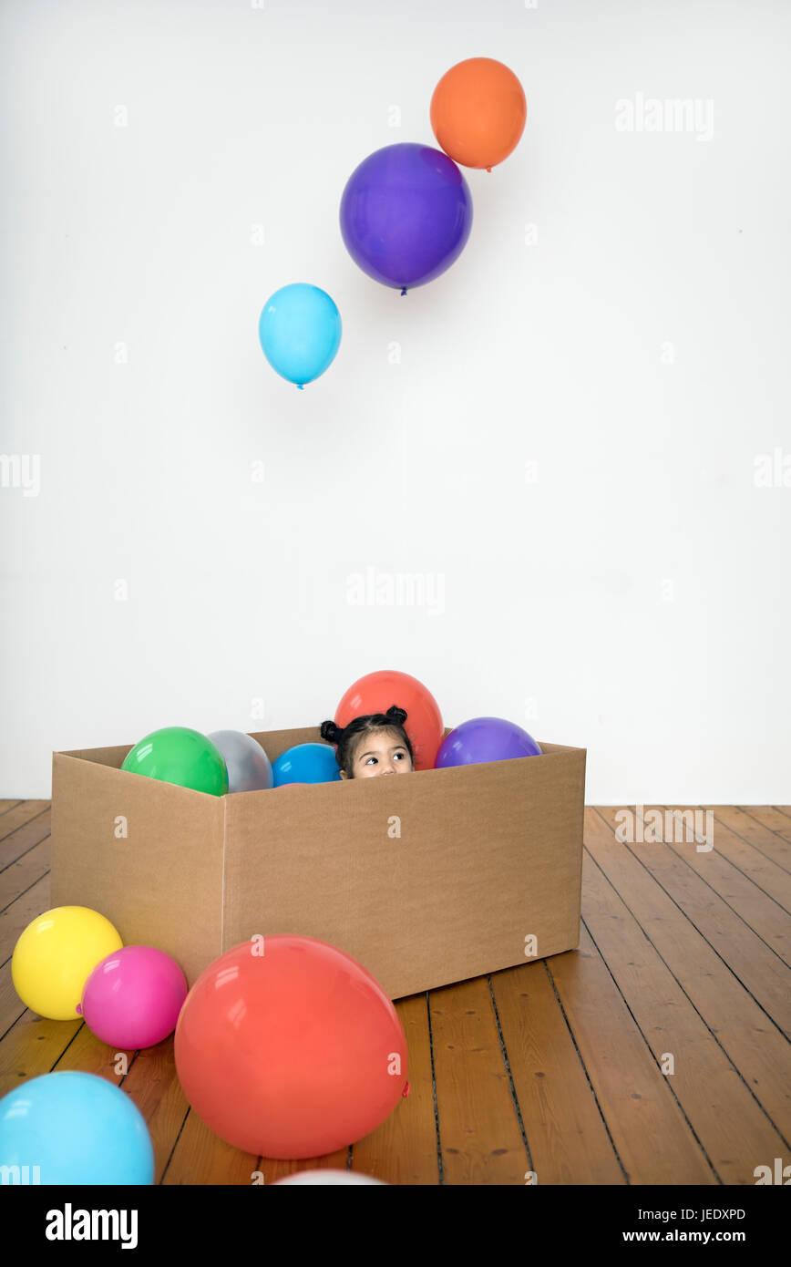 Girl inside cardboard box with balloons Stock Photo - Alamy