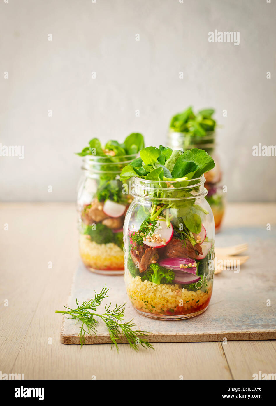 Preserving jar of buckwheat salad with vegetables and diced Striploin ...