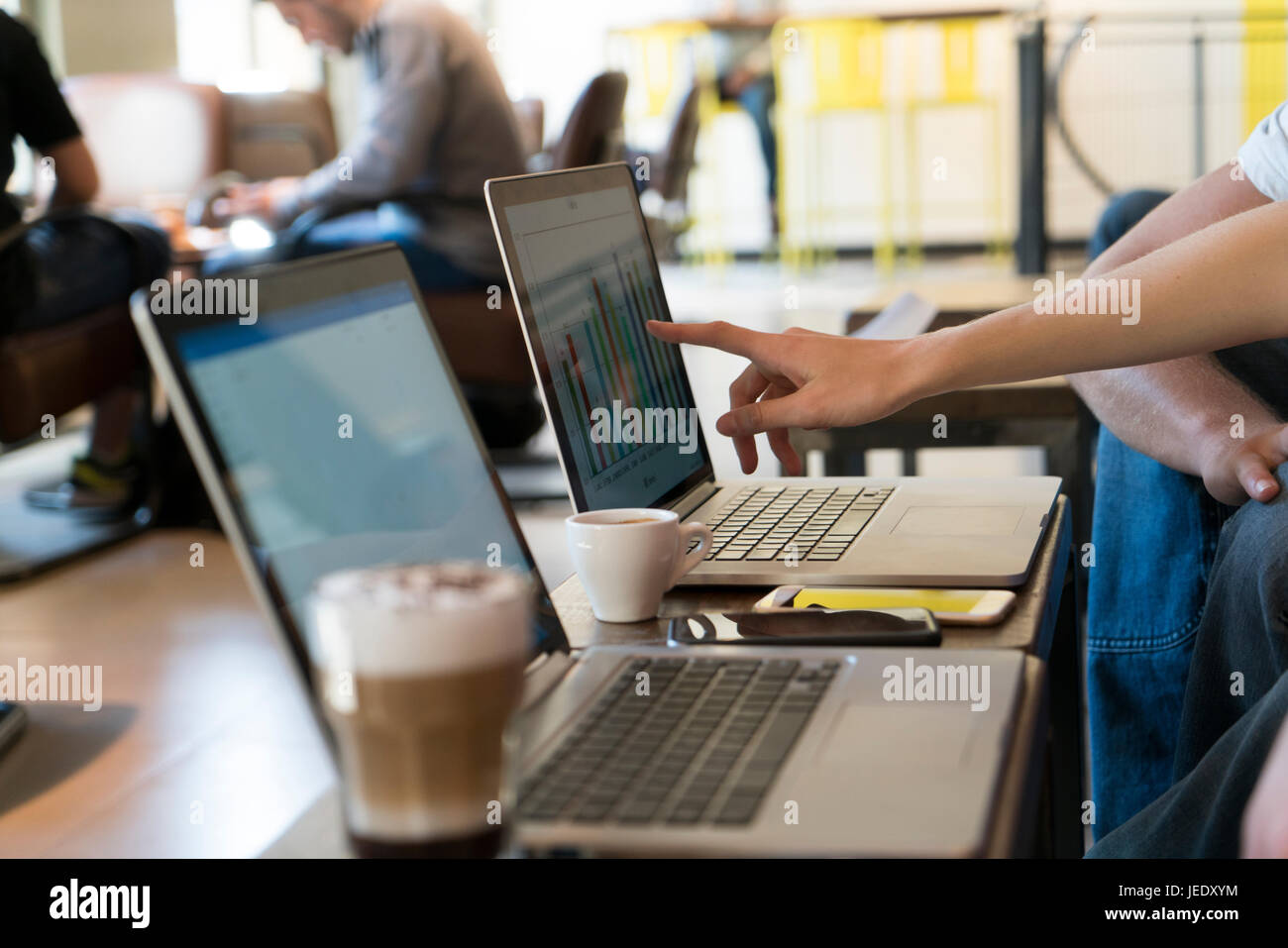 Analyzing bar chart on laptop monitor in a cafe Stock Photo - Alamy