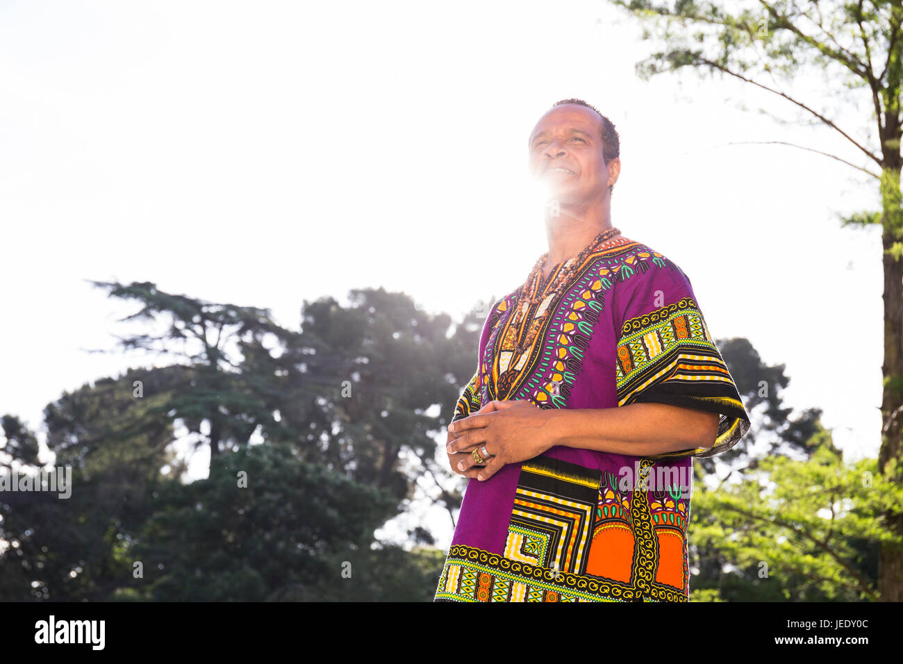 Portrait of smiling man standing at backlight wearing traditional ...