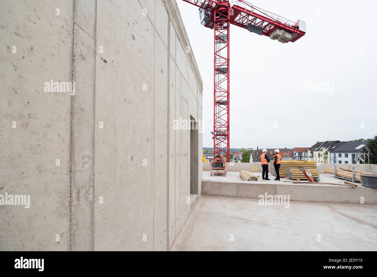 Two men wearing safety vests talking on construction site Stock Photo ...